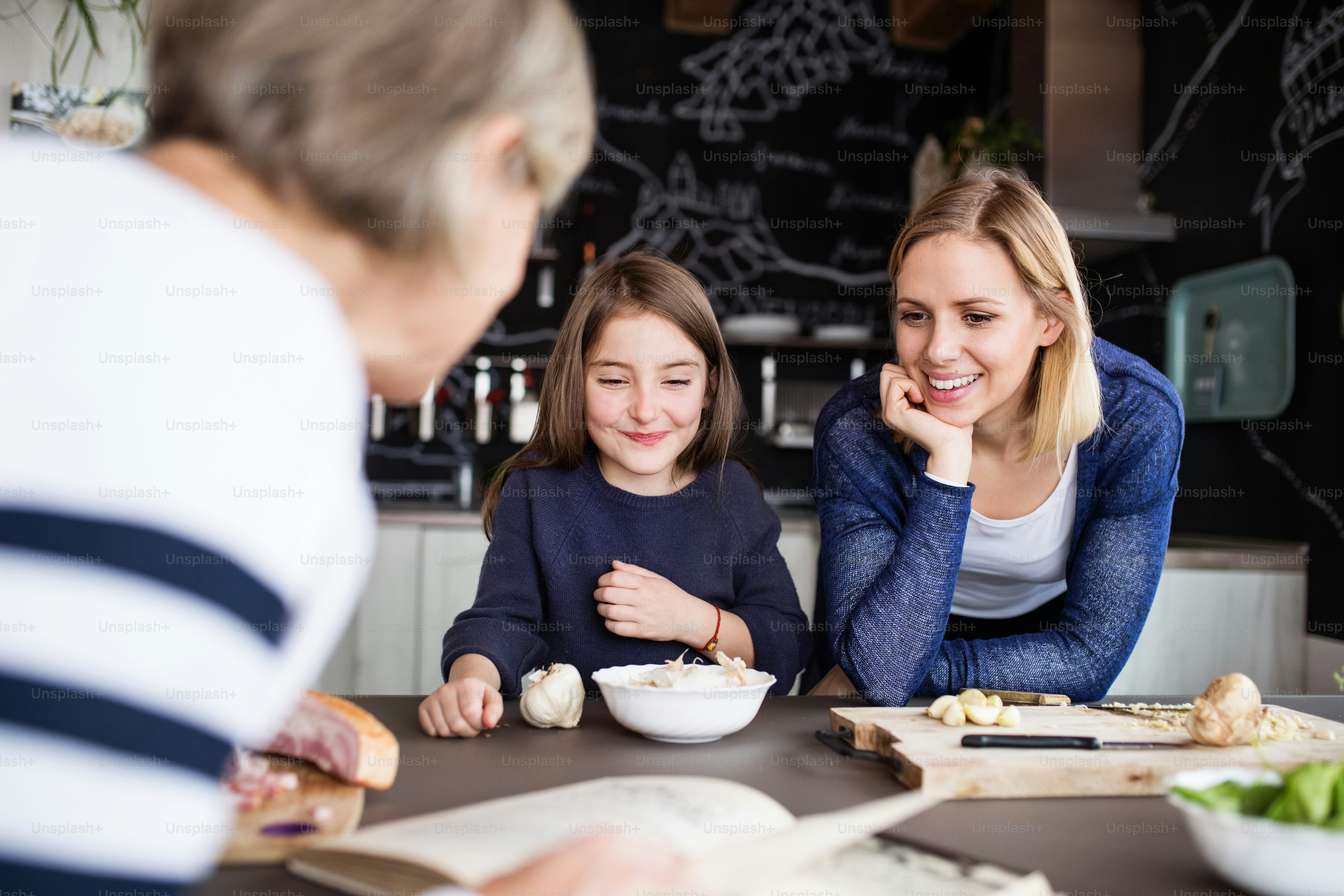 Une petite fille avec sa mère et sa grand-mère à la maison, en train de ...