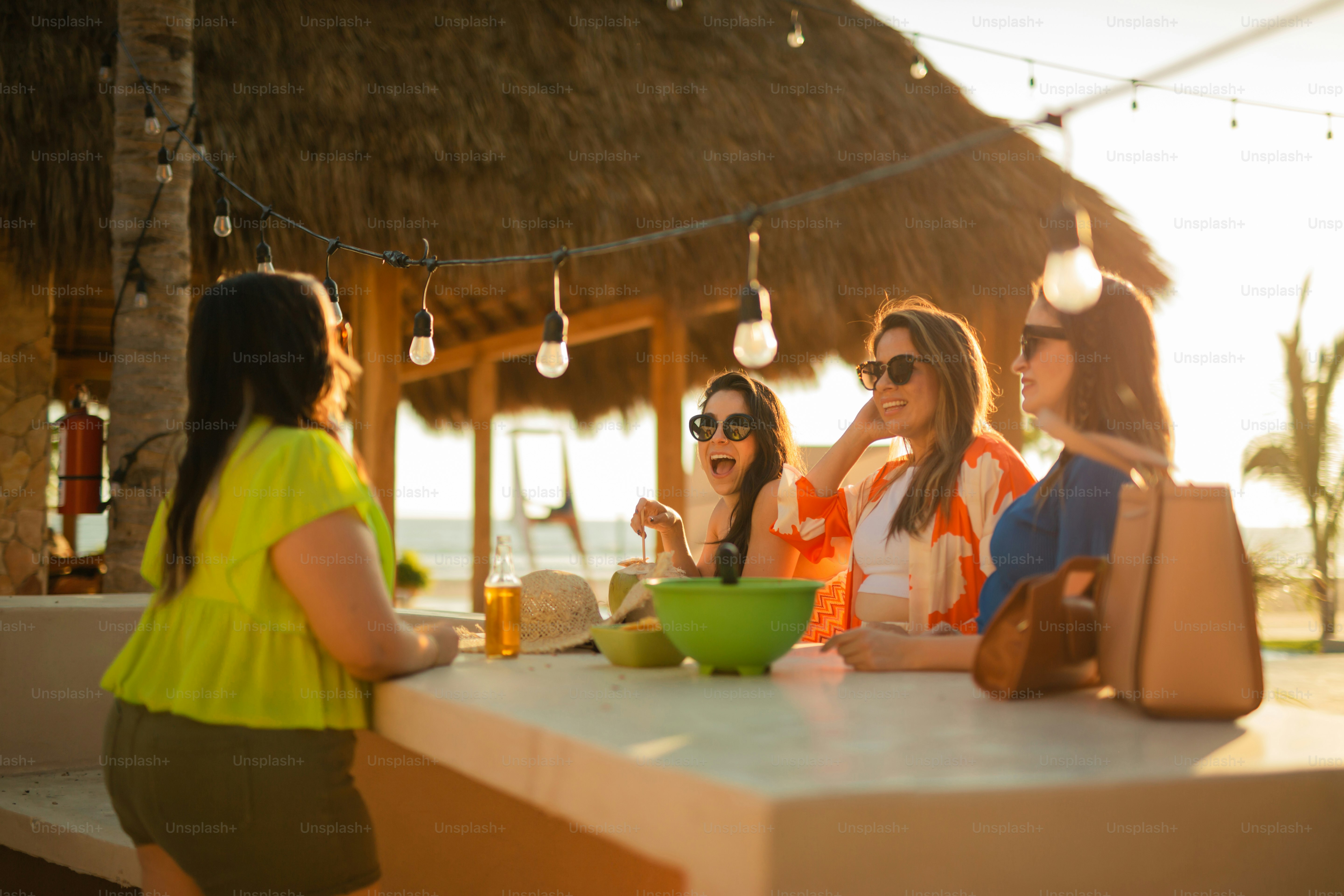 A group of women sitting around a table eating food photo – Party Image ...