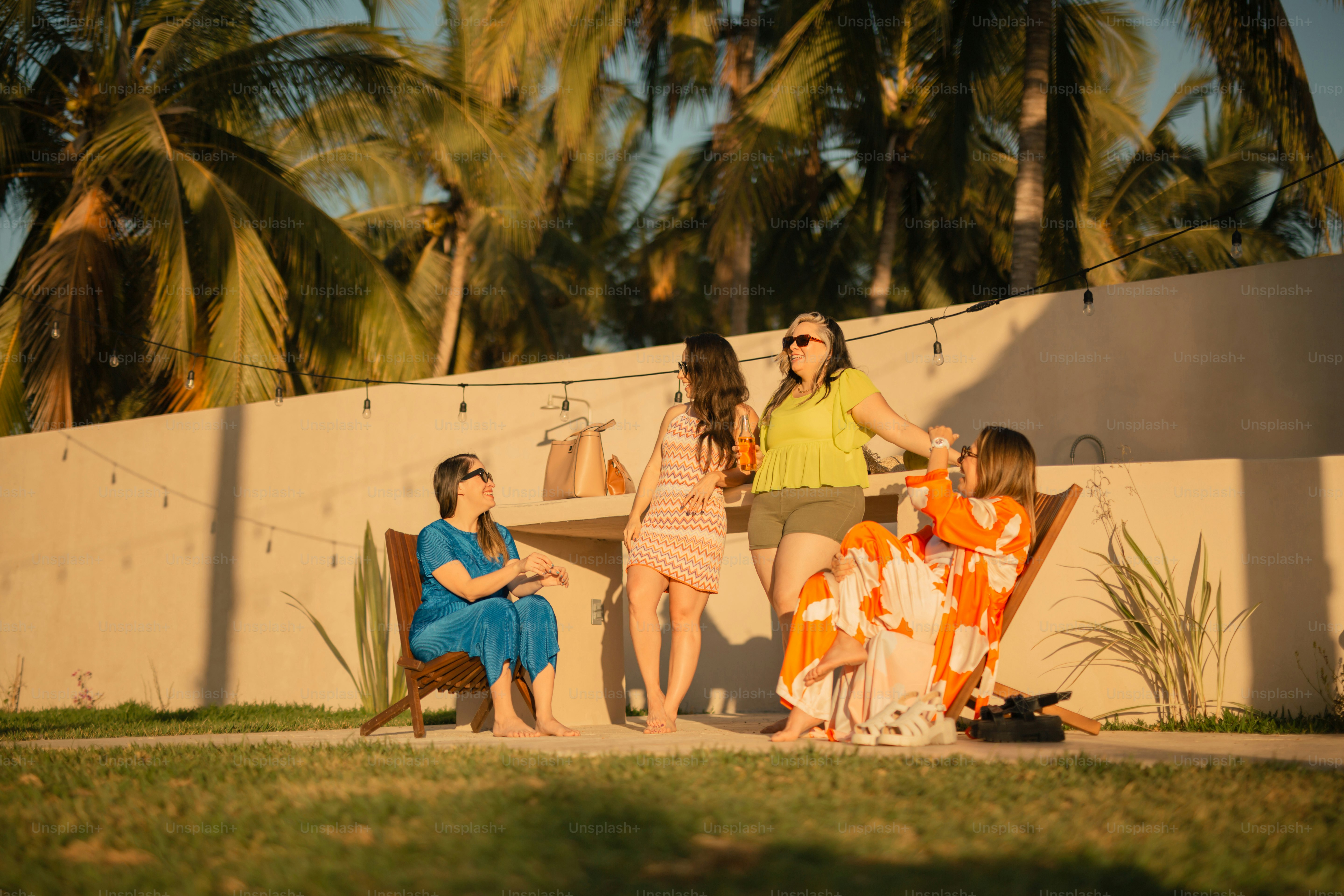 A group of women sitting on top of a lush green field photo – Spring ...