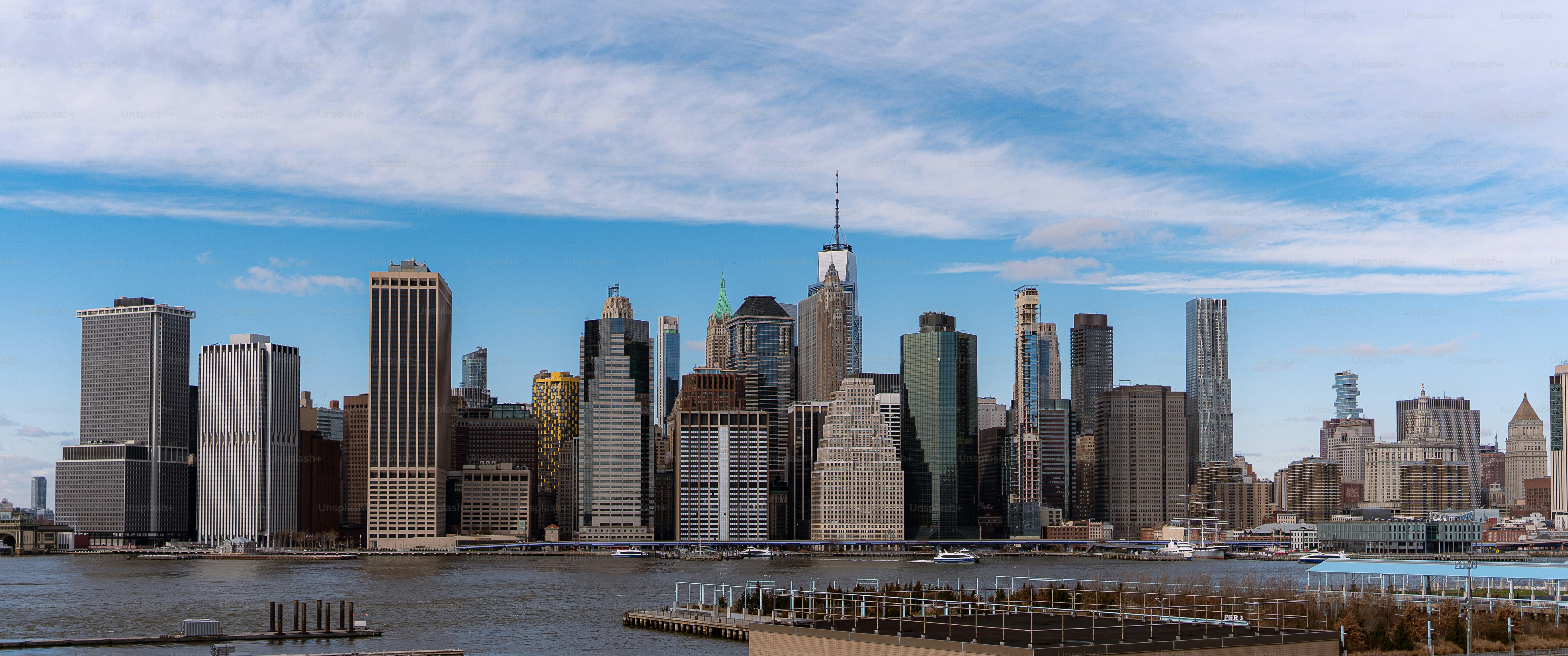 A boat traveling down a river next to a large city photo – City Image ...