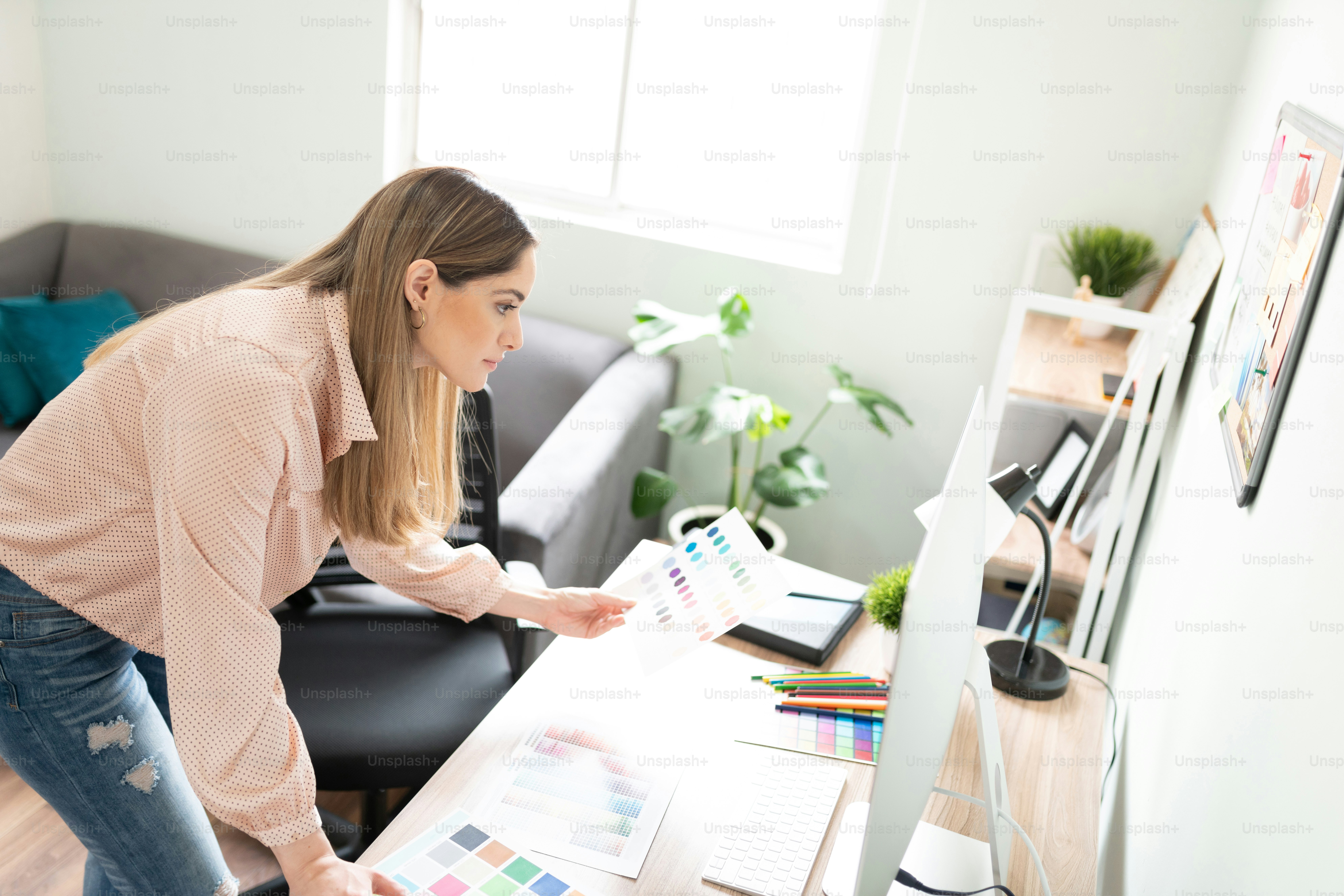 Caucasian woman working as a designer and looking busy in her office ...