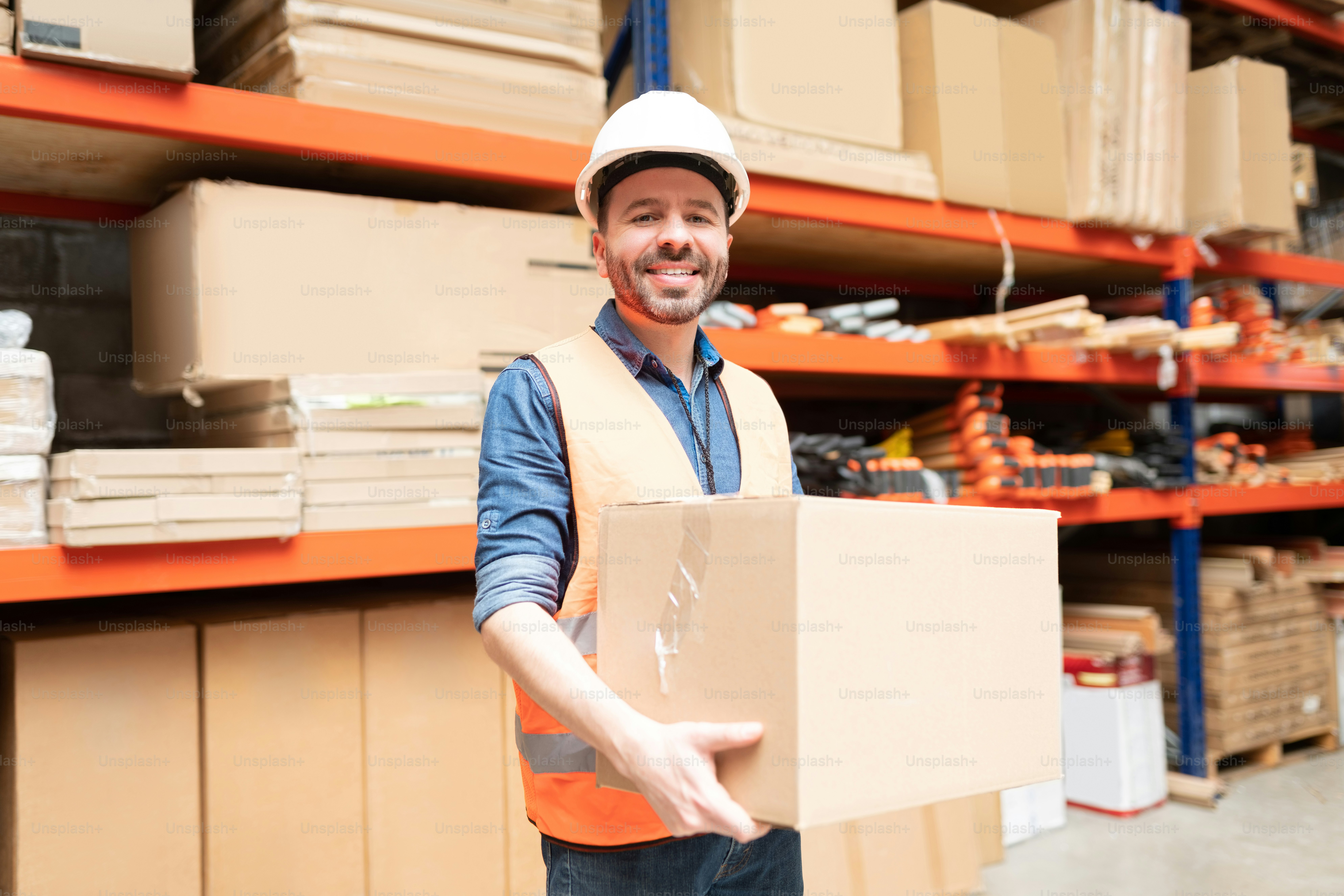 Happy good looking worker holding cardboard box while making eye ...