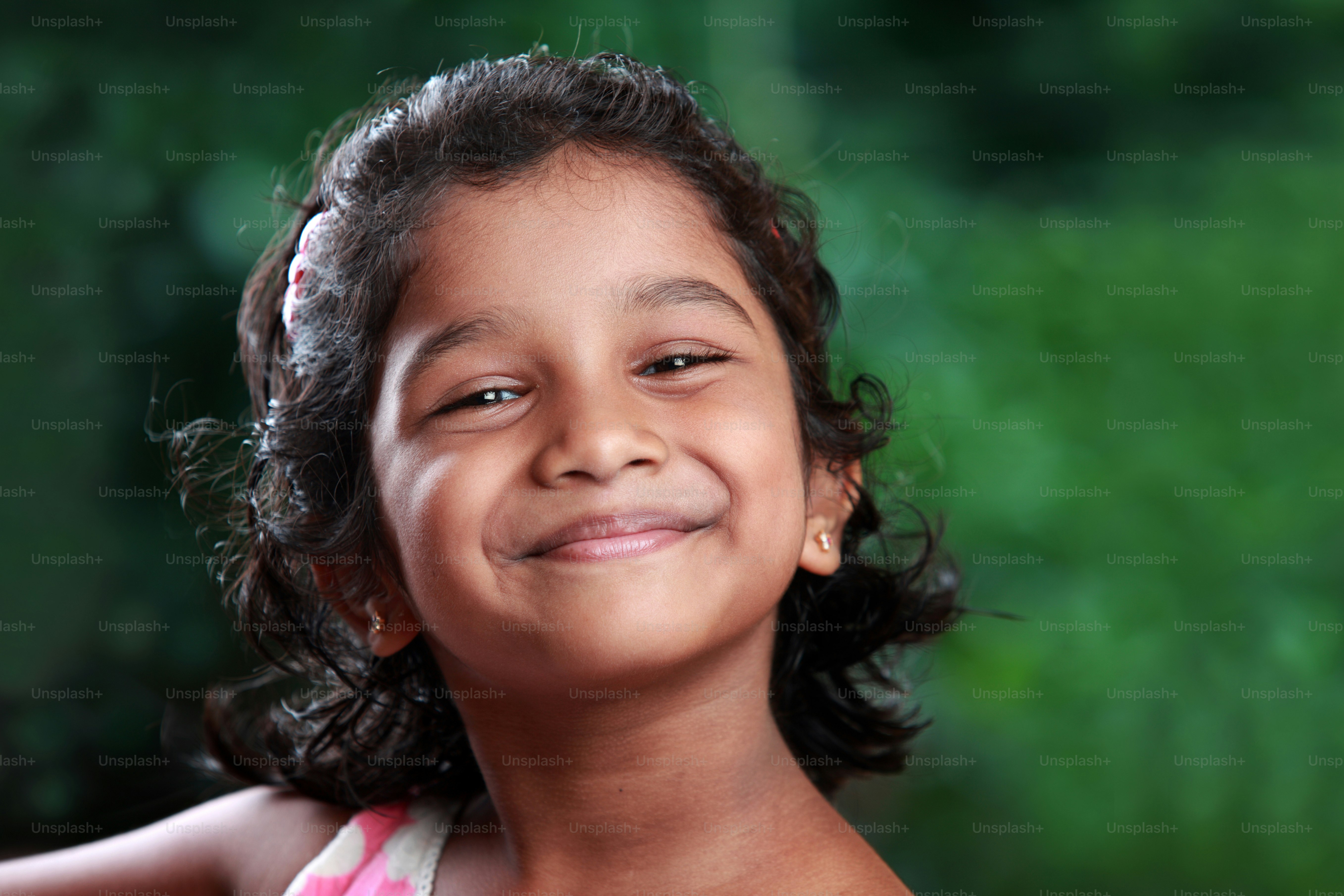 Smiling portrait of a little girl of Indian origin in the outdoors ...