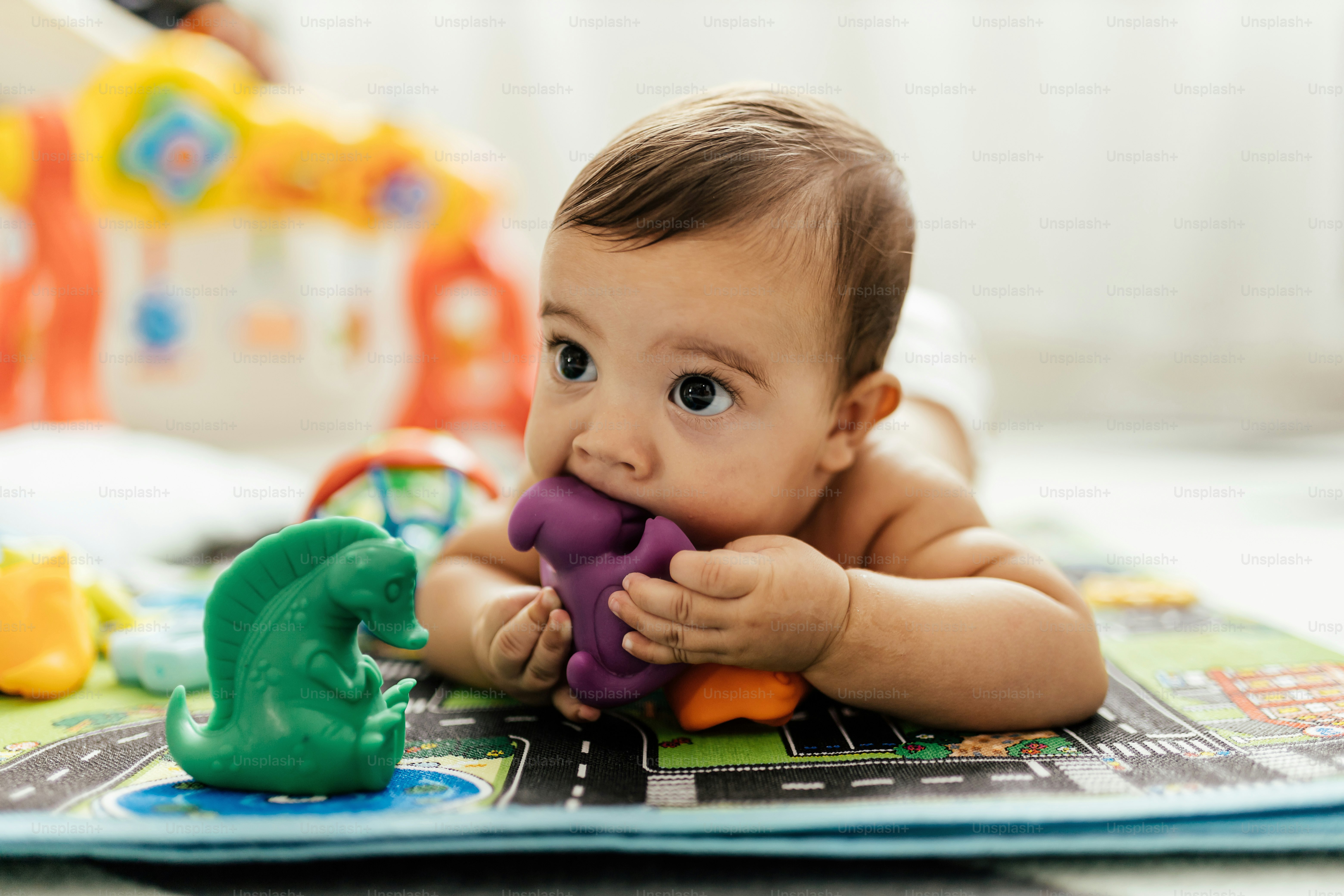 Baby playing with toys on the floor. photo – White people Image on Unsplash