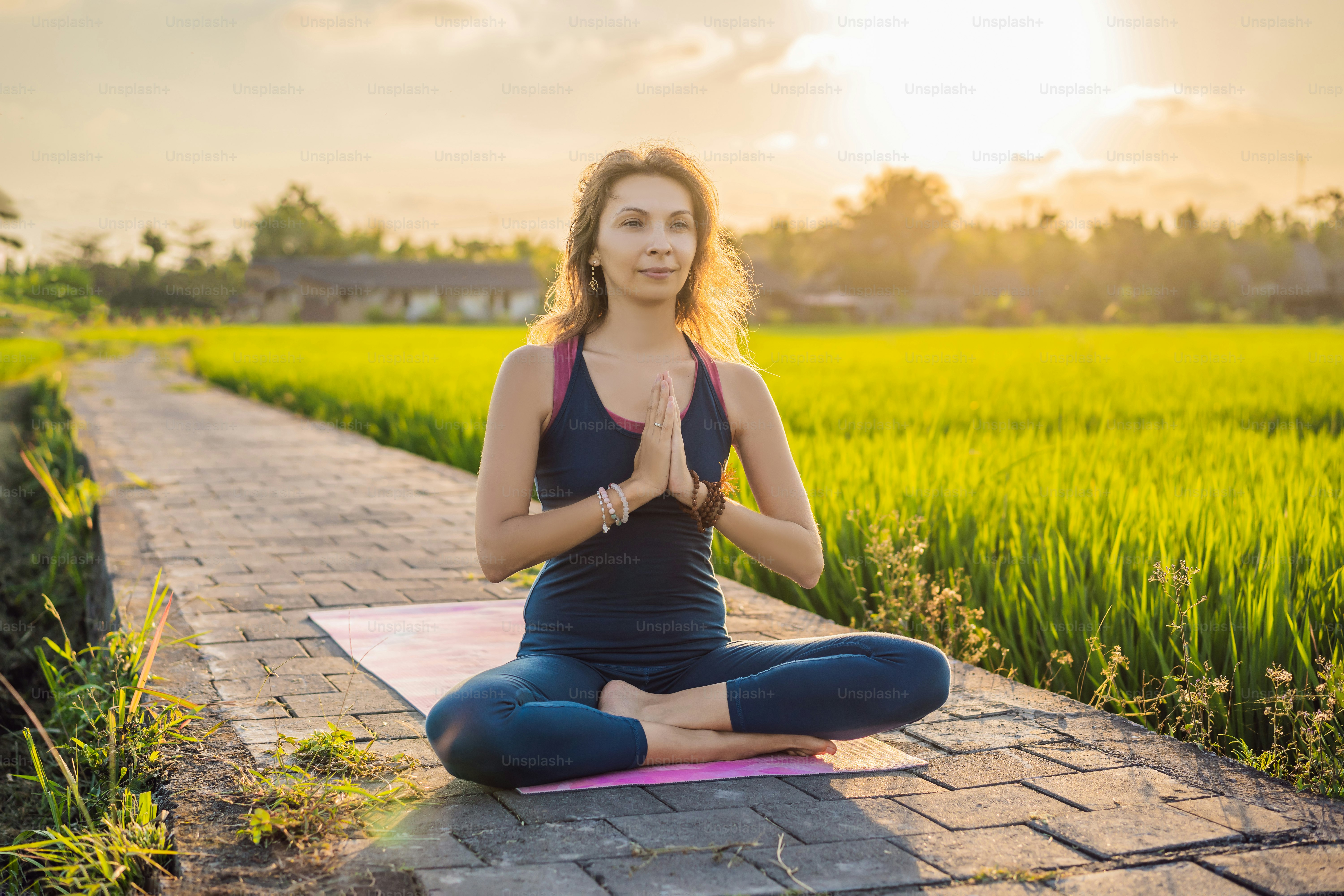 Young woman practice yoga outdoor in rice fields in the morning during ...