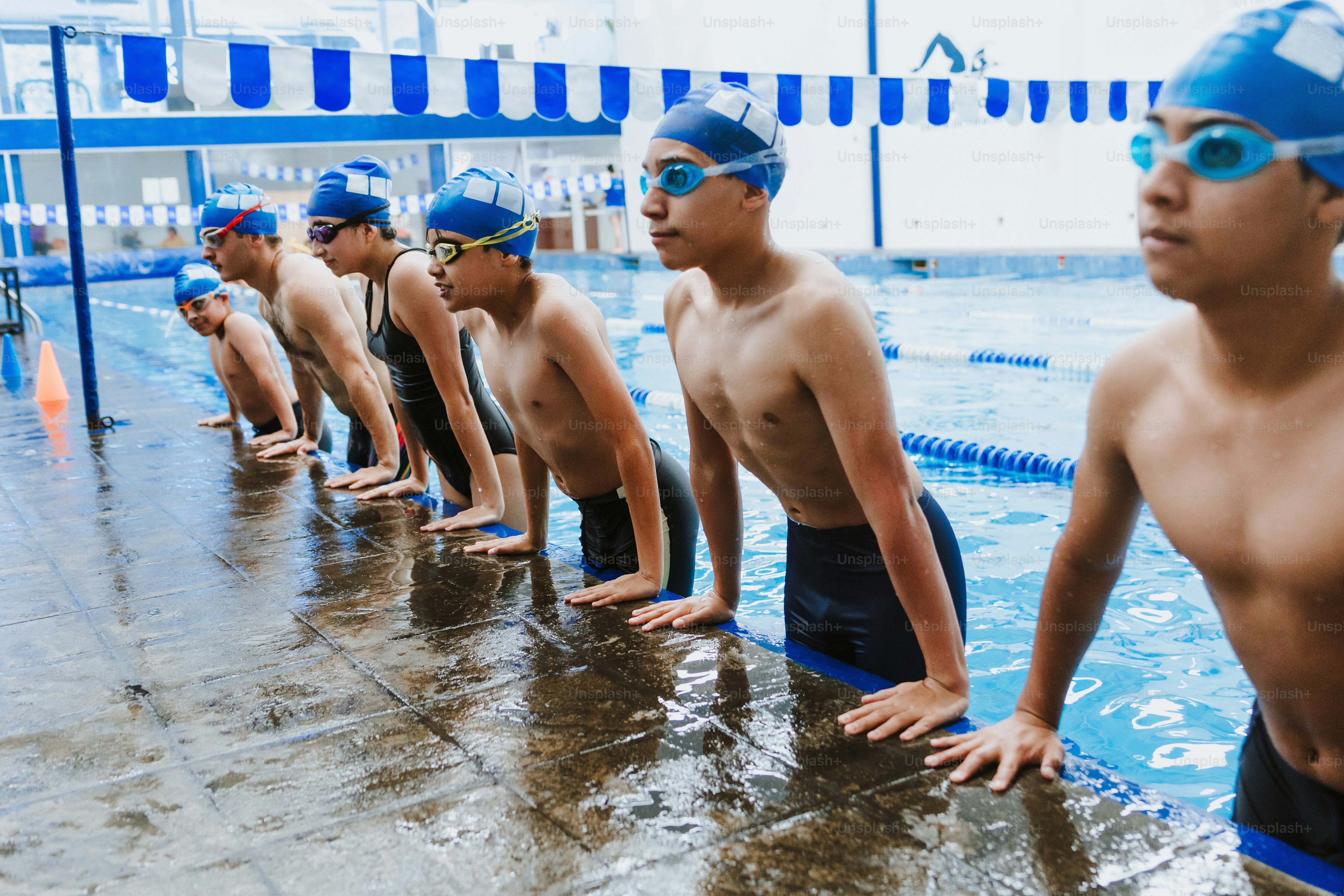 Hispanic young man swimmer athlete wearing cap in a swimming training ...