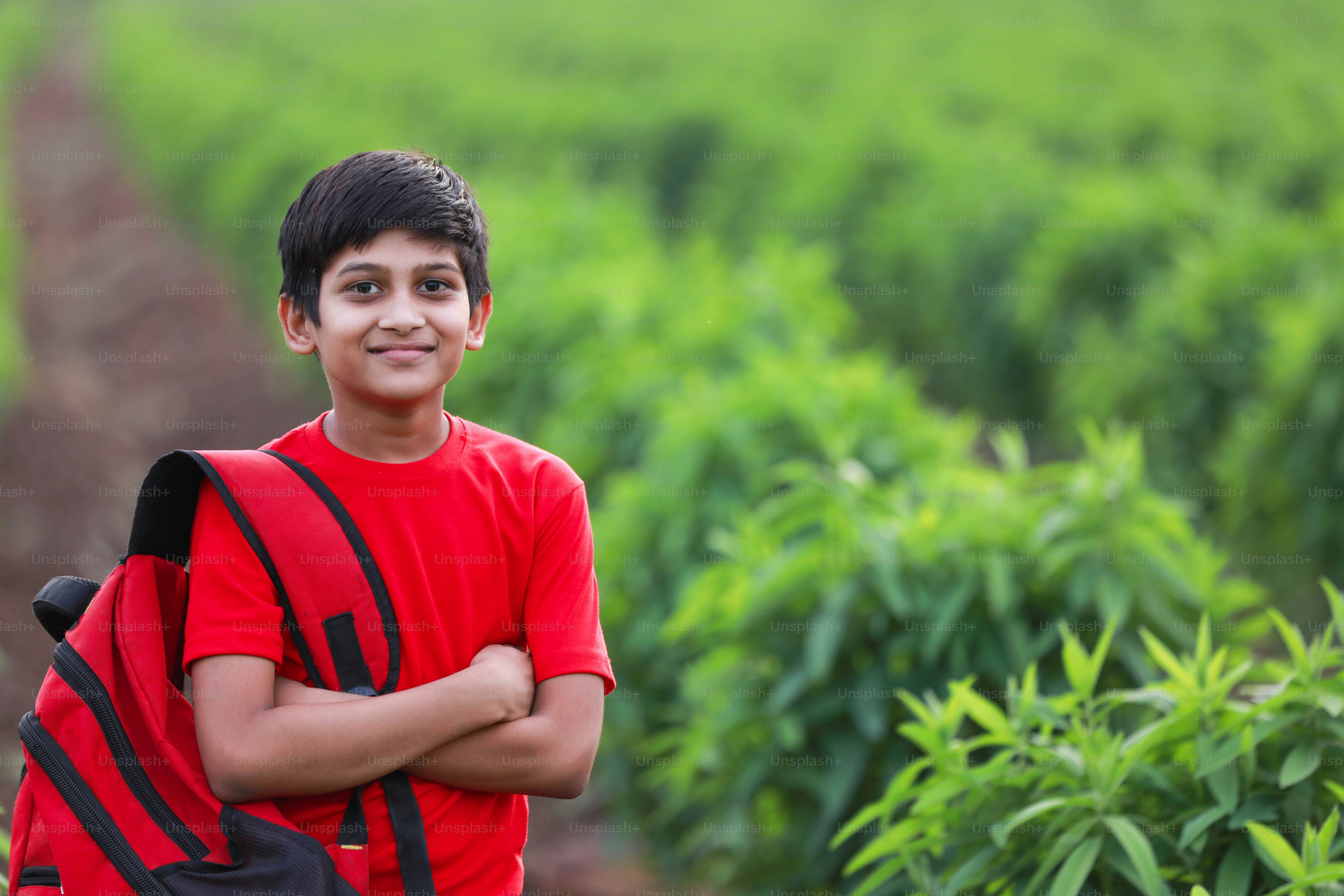 Cute indian child with school bag and running at agriculture field ...