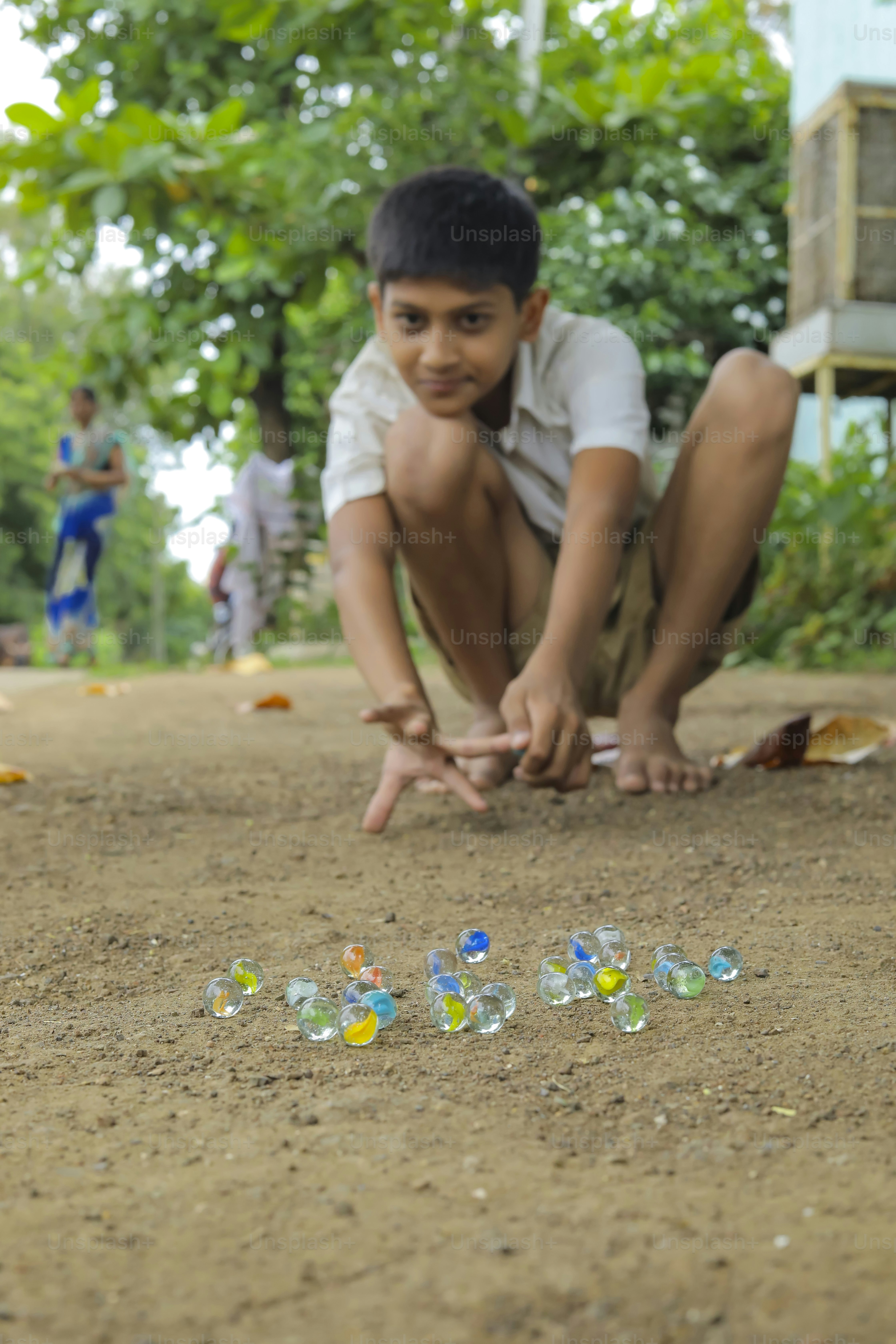 Indian child playing with glass marbles which is an old Indian village ...