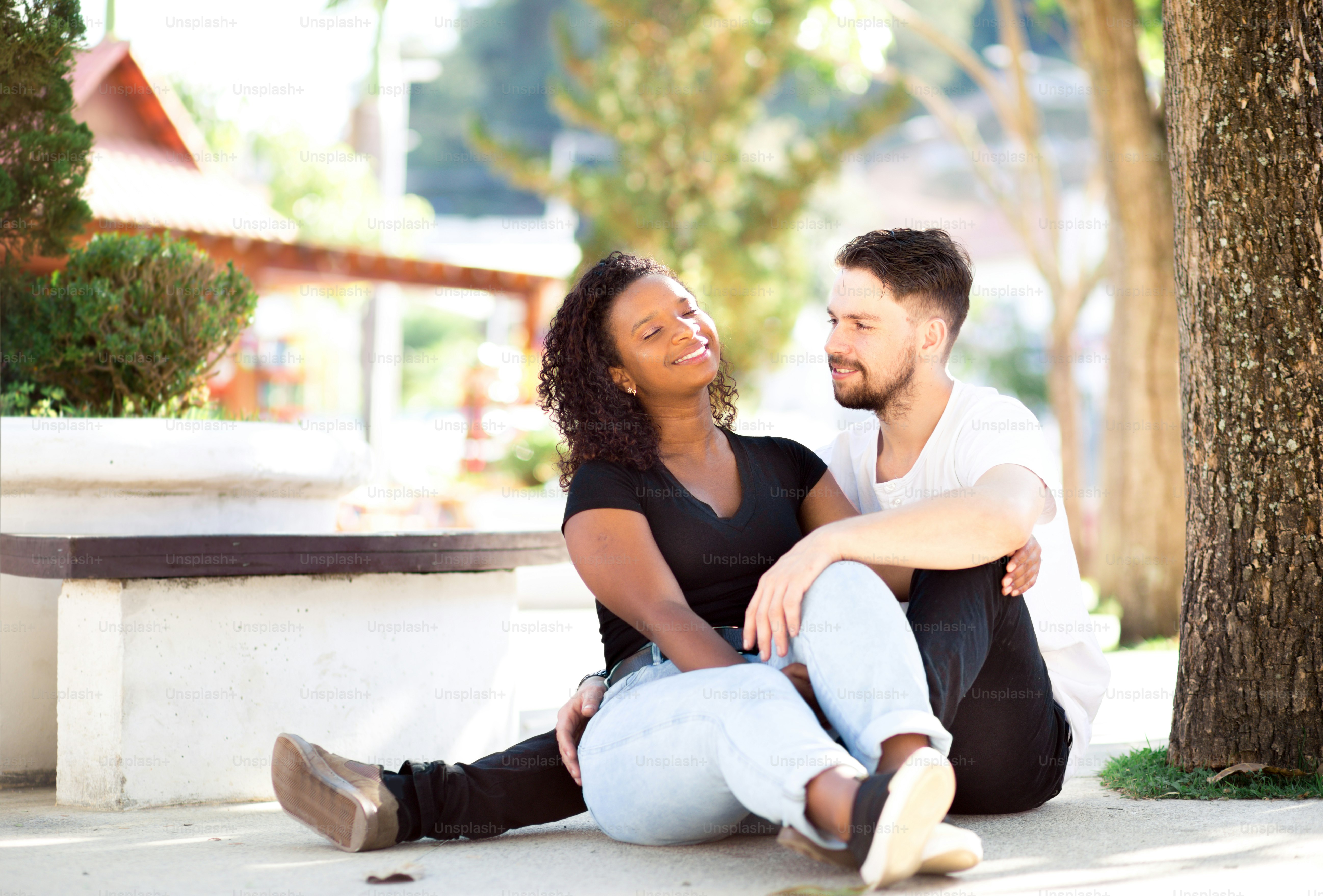 Couple heureux assis sur la place parlant et échangeant de l’affection ...