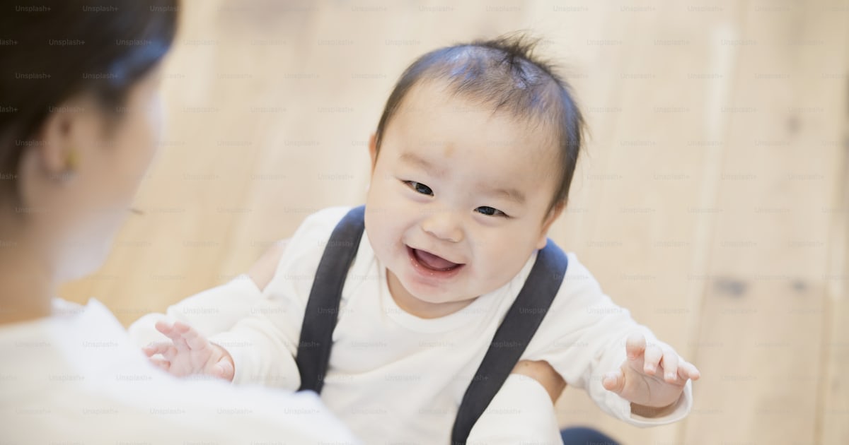 미소를 지으며 아기를 안고 있는 아시아의 젊은 엄마 사진 Unsplash의 초상 이미지