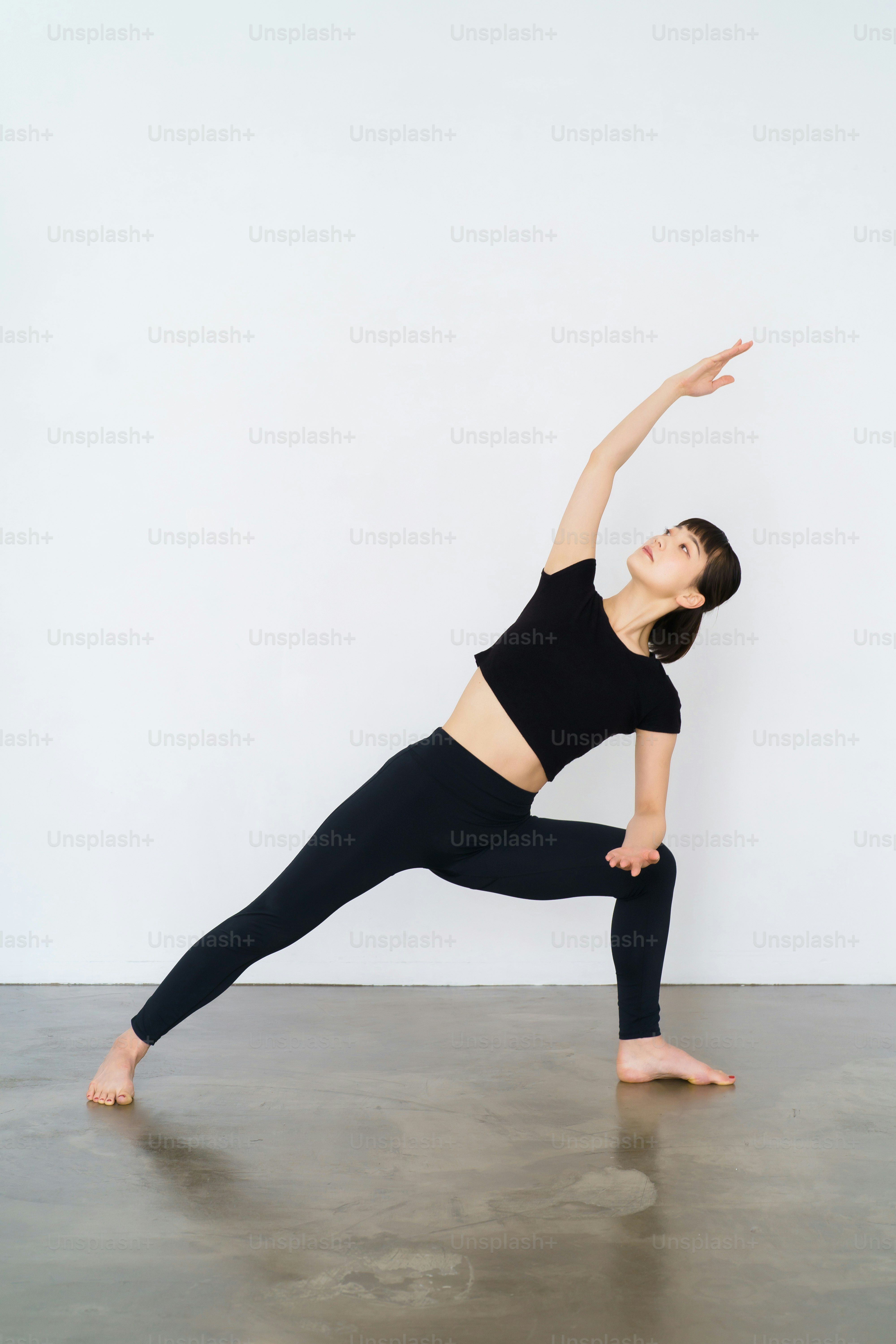 A woman doing yoga in a sole pose indoors photo – One woman only Image ...