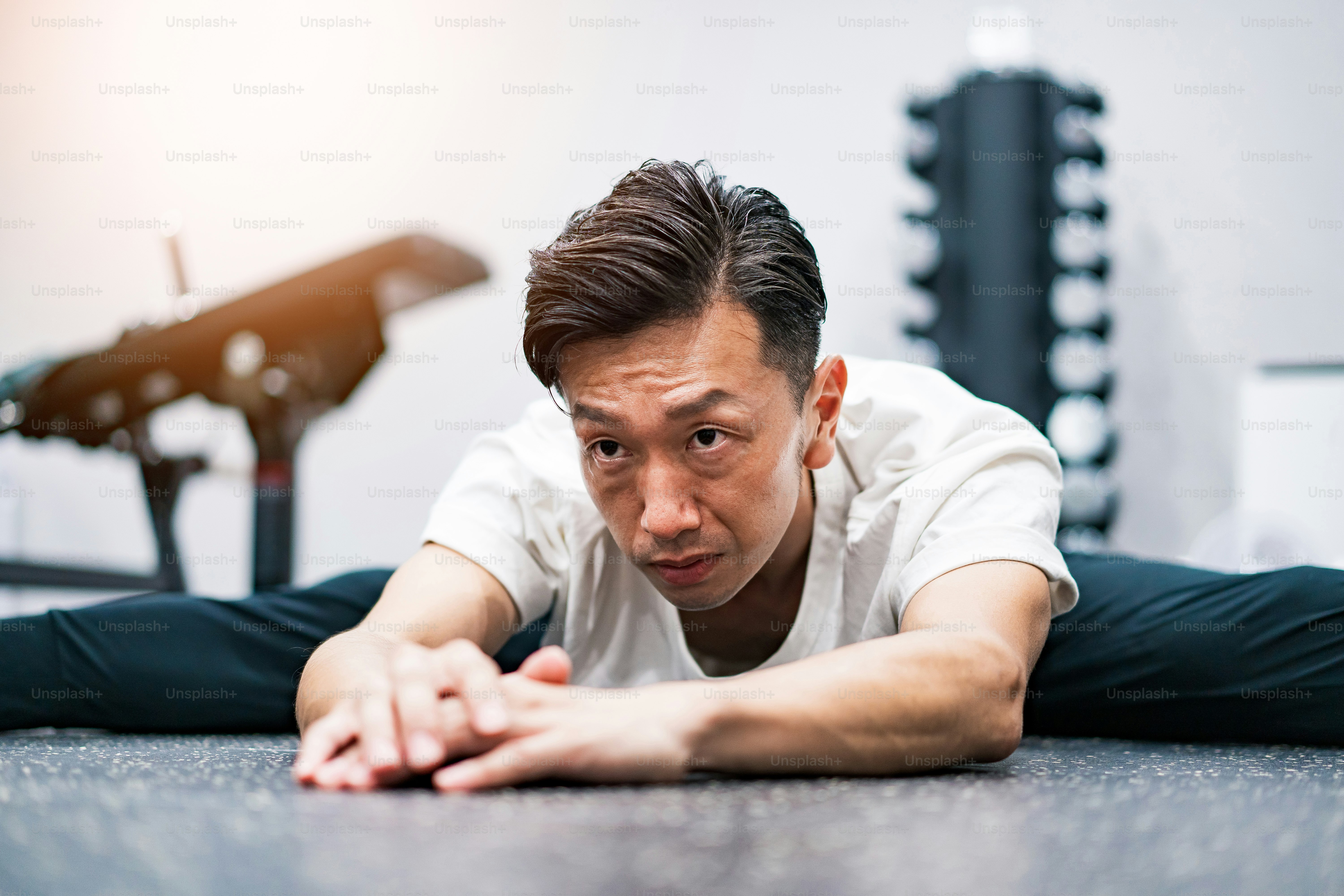 Middle-aged man doing stretching exercises in the gym photo ...