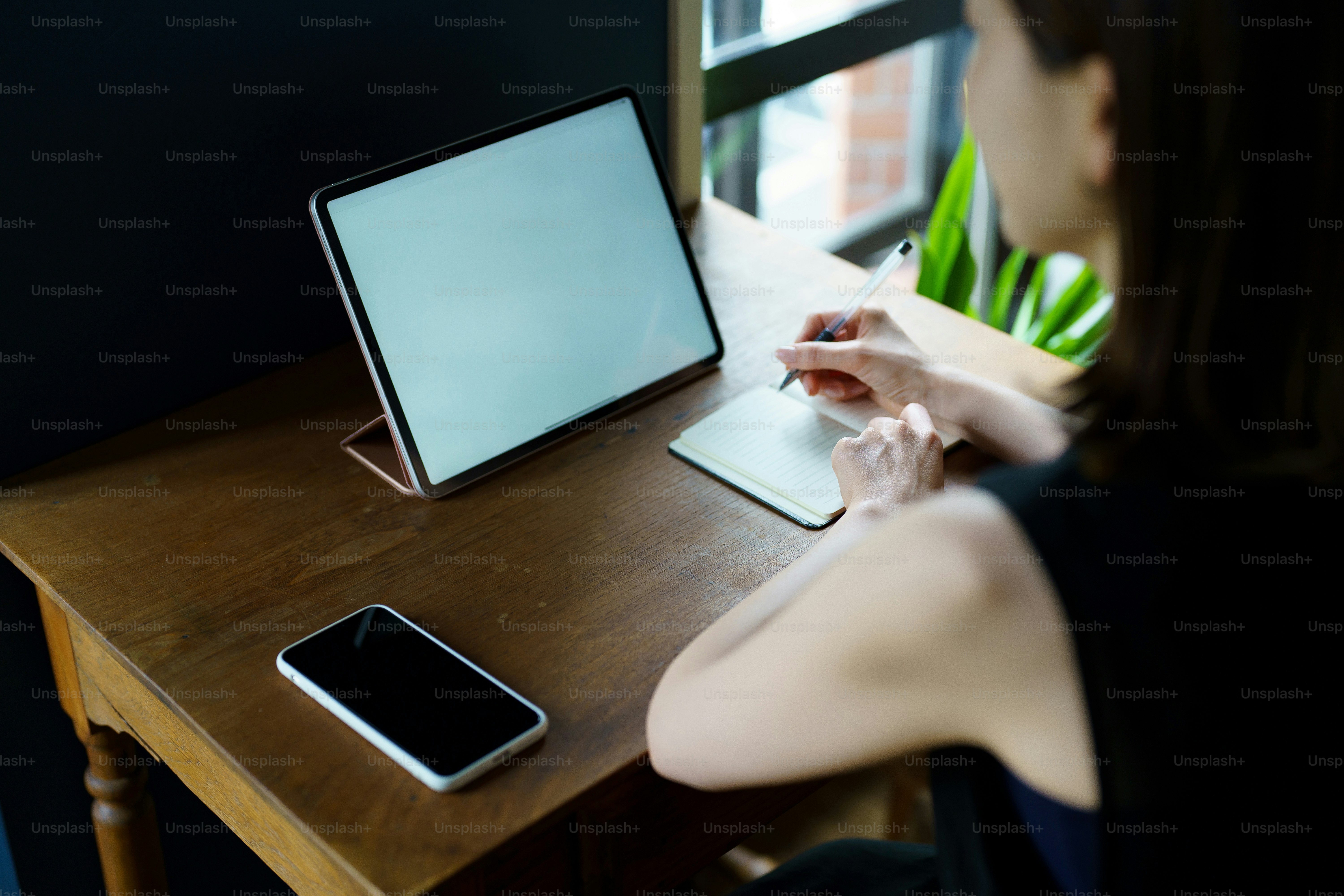 A woman who communicates online using a tablet PC in the room photo ...