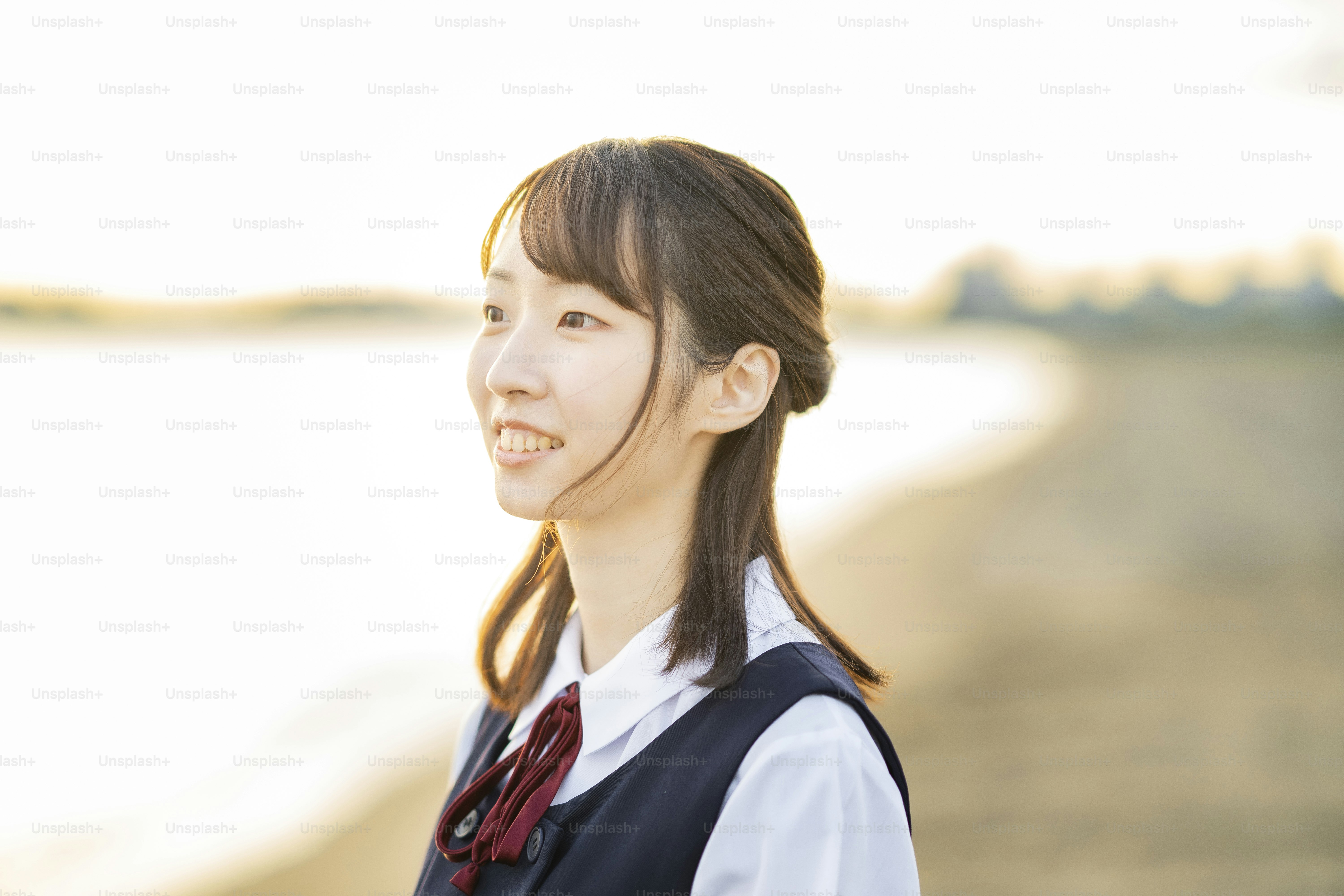 Asian female high school student wrapped in the setting sun photo ...