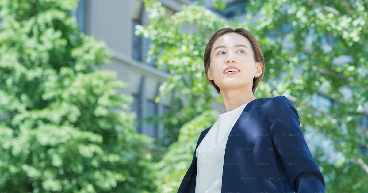 사무실 구역에 서 있는 웃고 있는 젊은 여성 사진 Unsplash의 한 사람 이미지