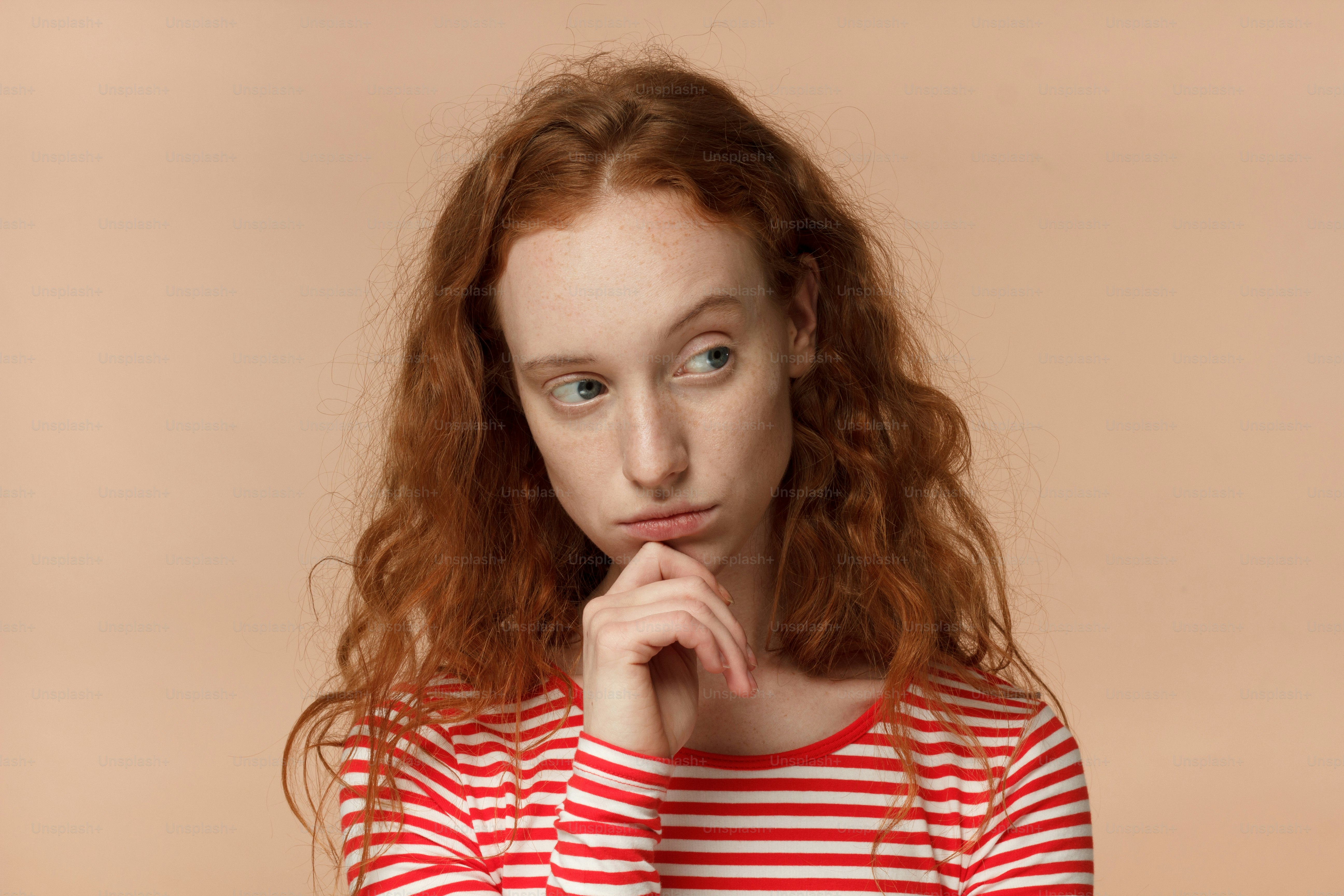 Closeup headshot of beautiful redhead woman isolated on peach ...