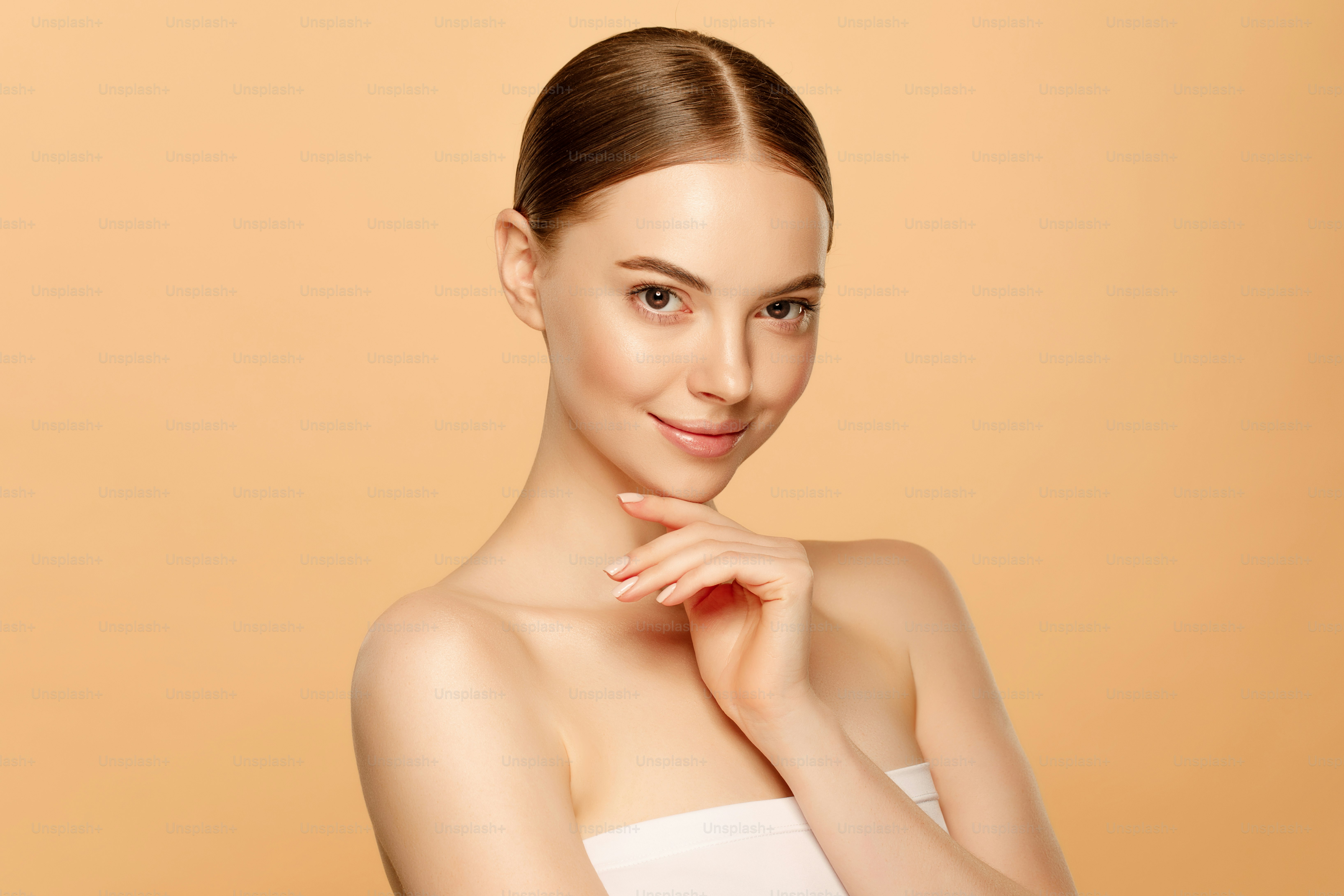 Portrait of young beautiful woman with brown eyes and glowing skin ...