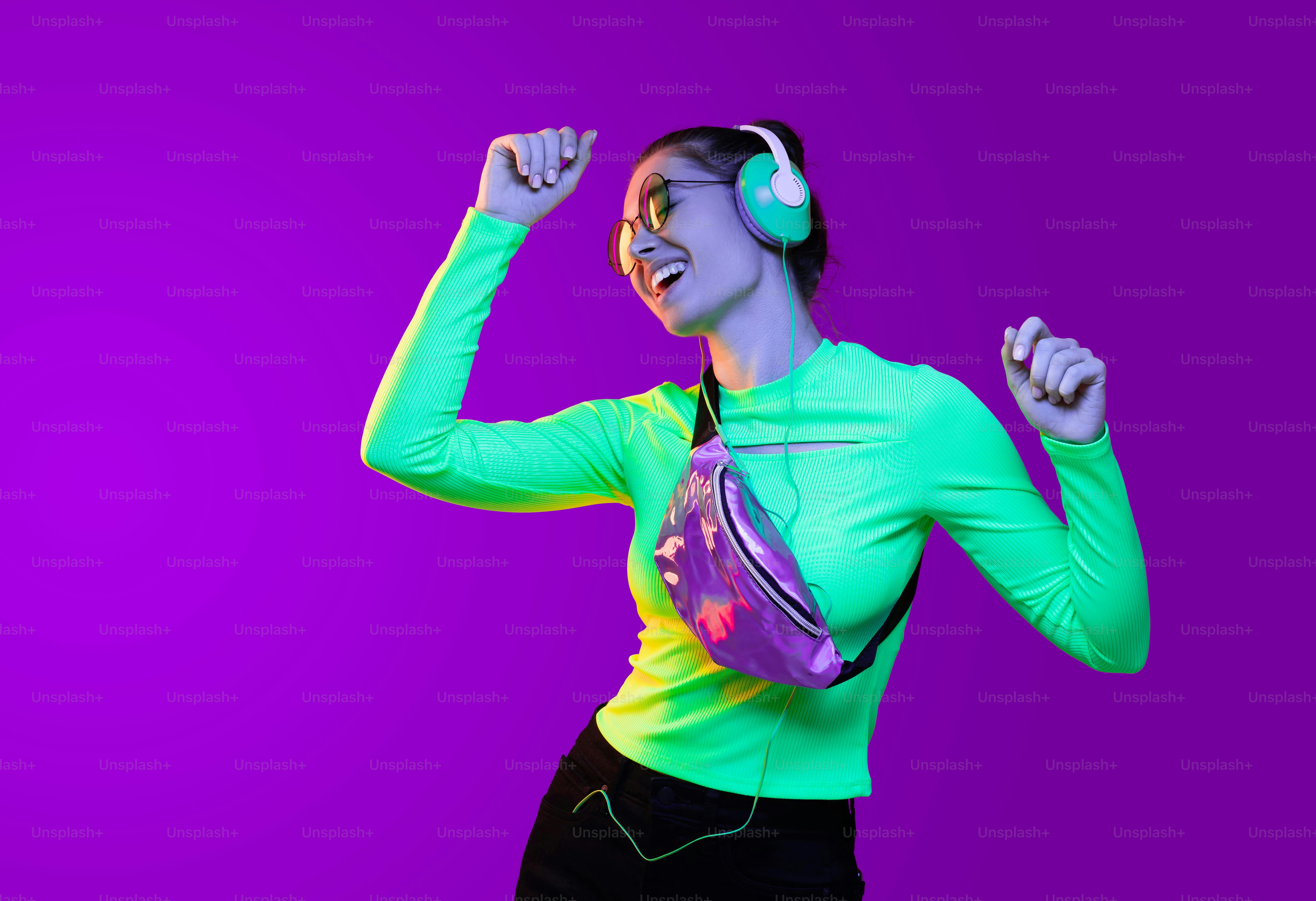 Young girl dancing to sounds of music listening in headphones, dressed ...