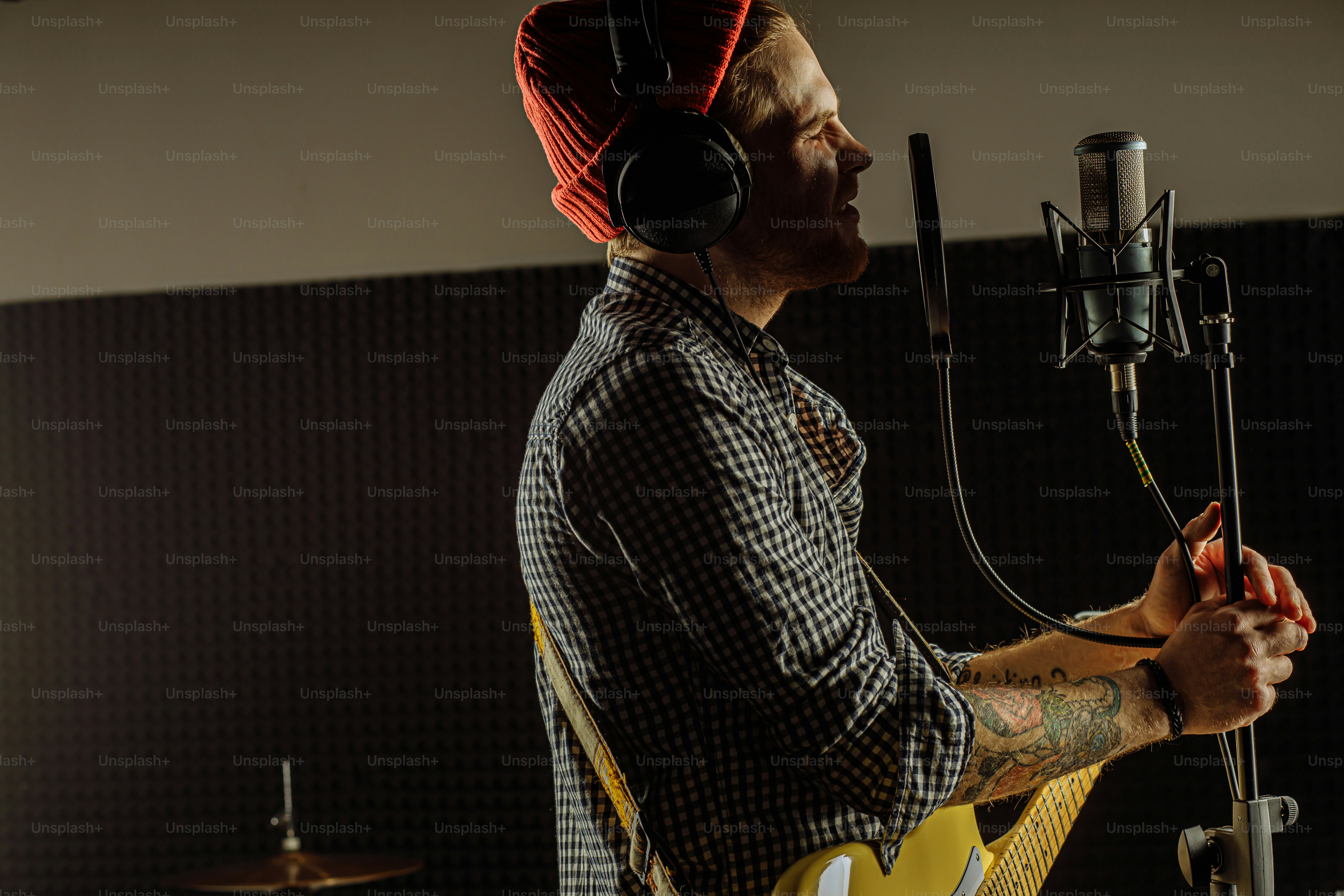 Young caucasian professional guitarist singing on microphone and ...