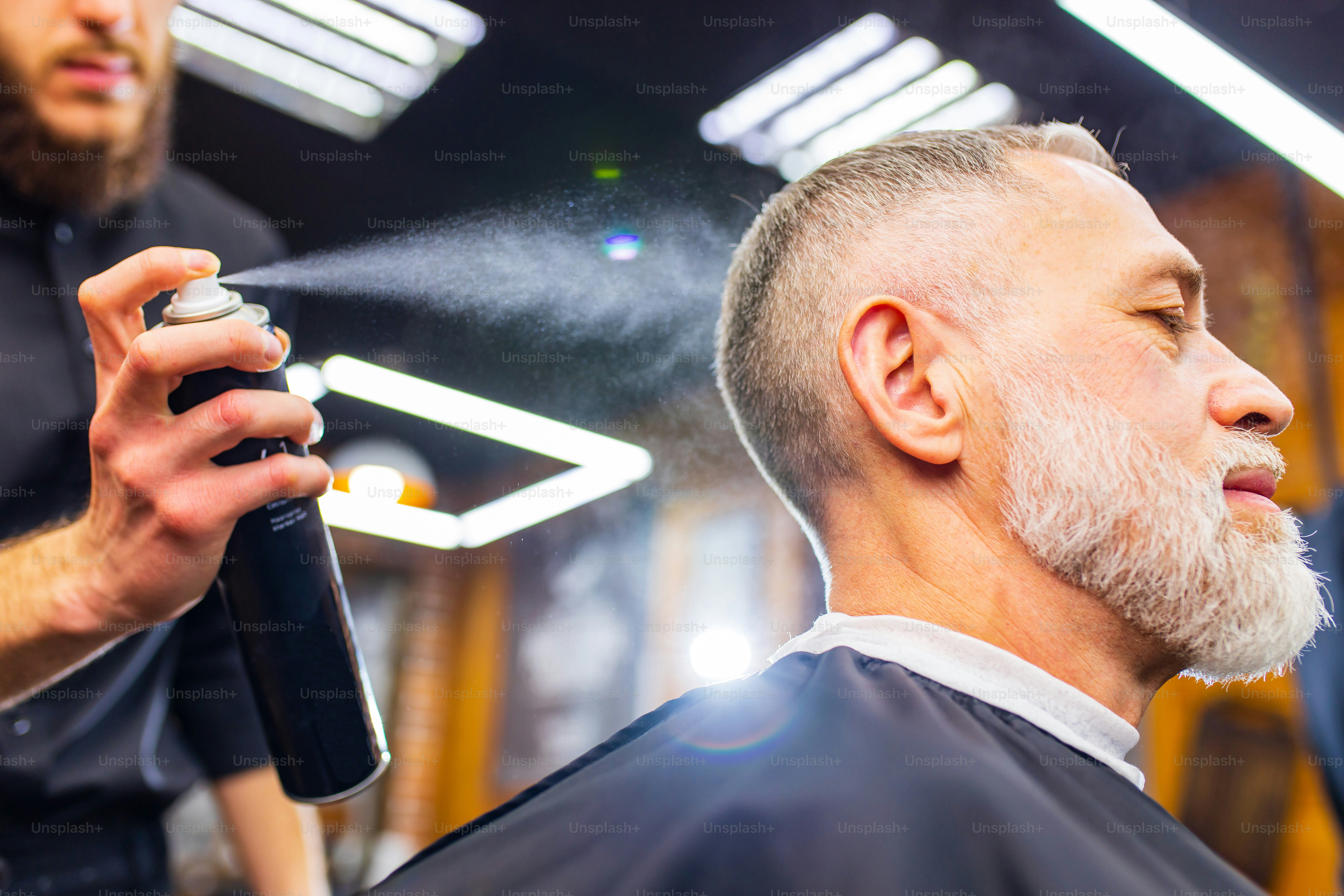 Senior handsome man visiting hairstylist in modern barber shop. photo ...