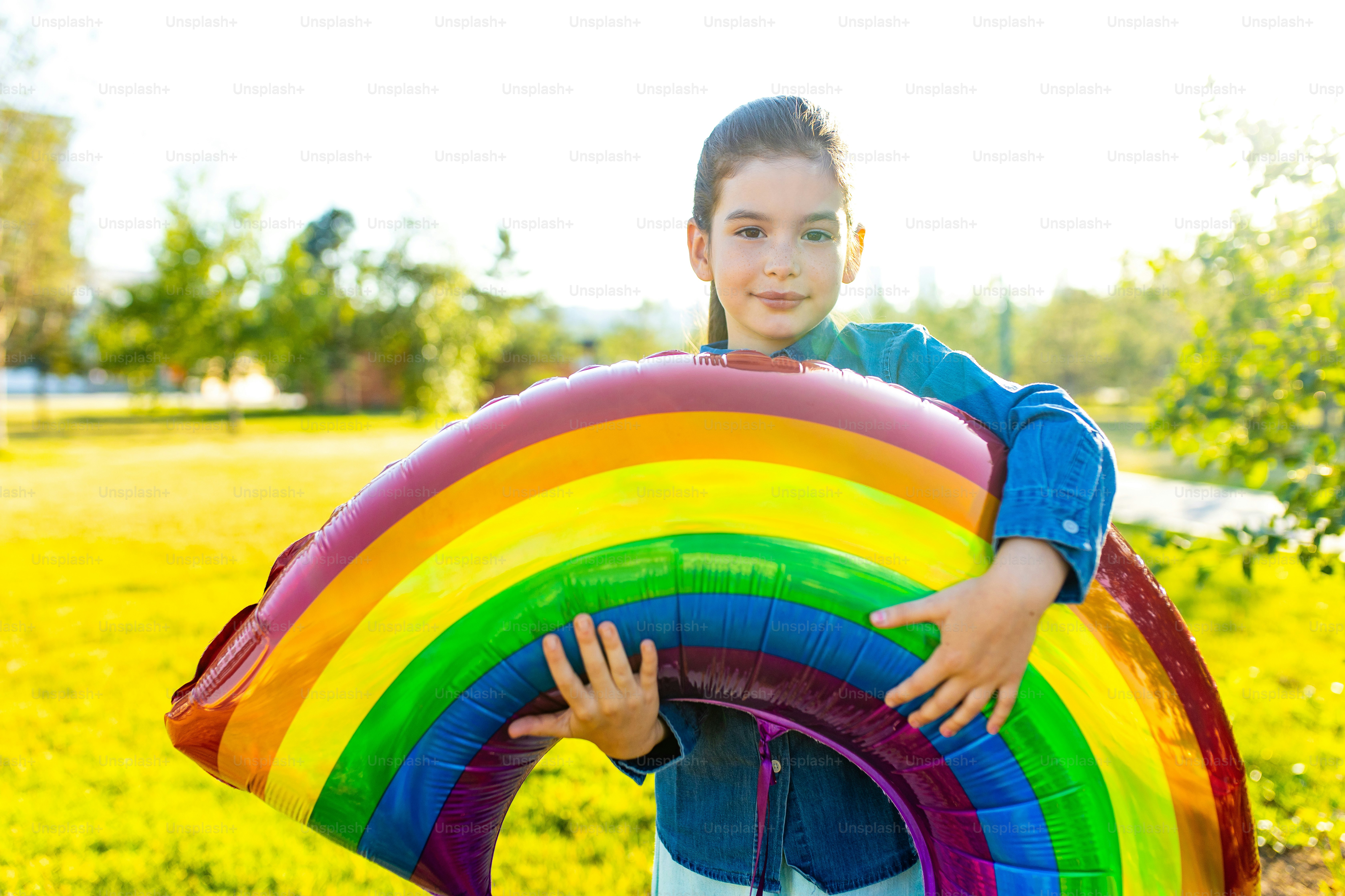 Beautiful latin hispanic seven years old girl with big rainbow balloon ...