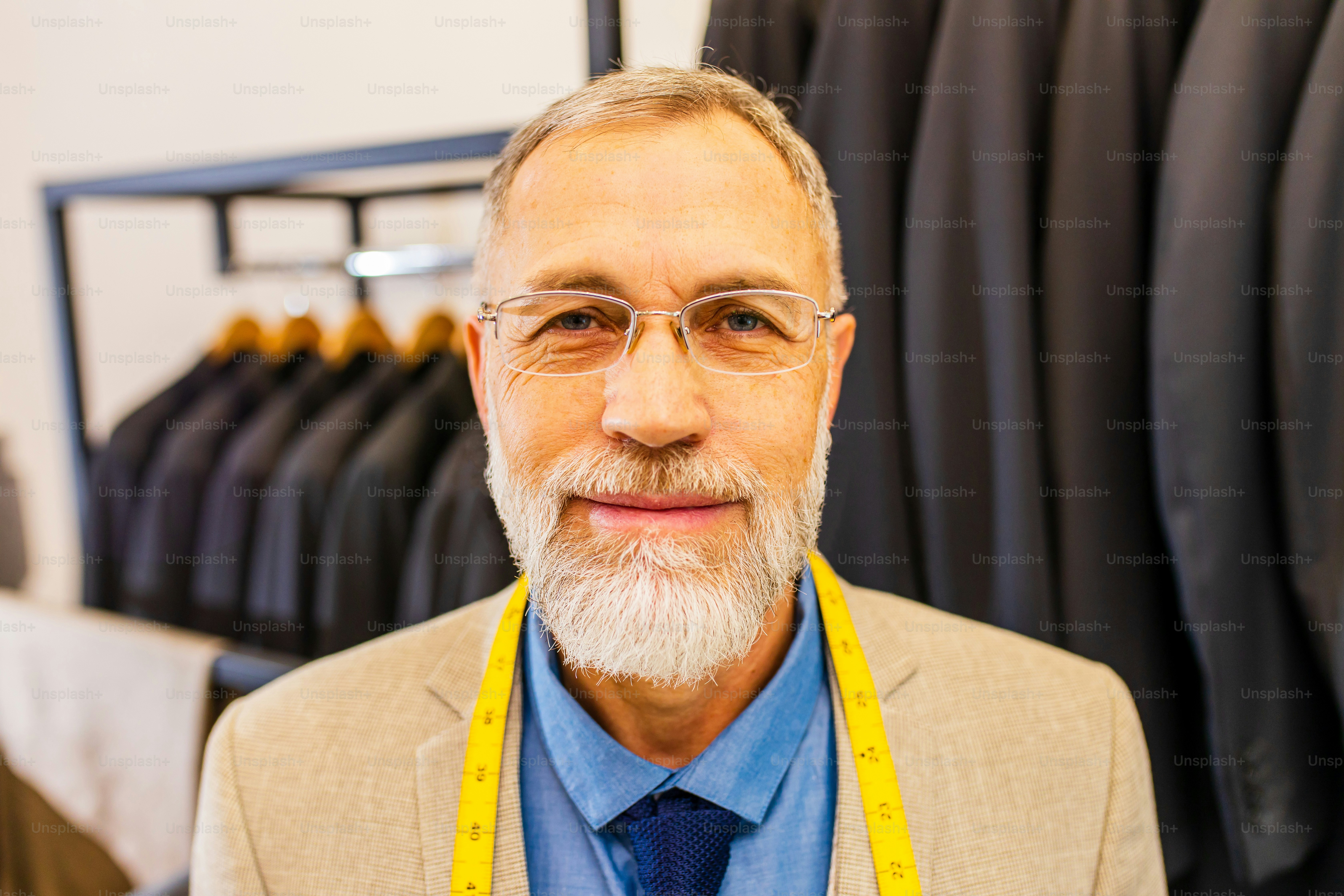 Well-dressed bearded mature handsome man working in his atelier studio ...