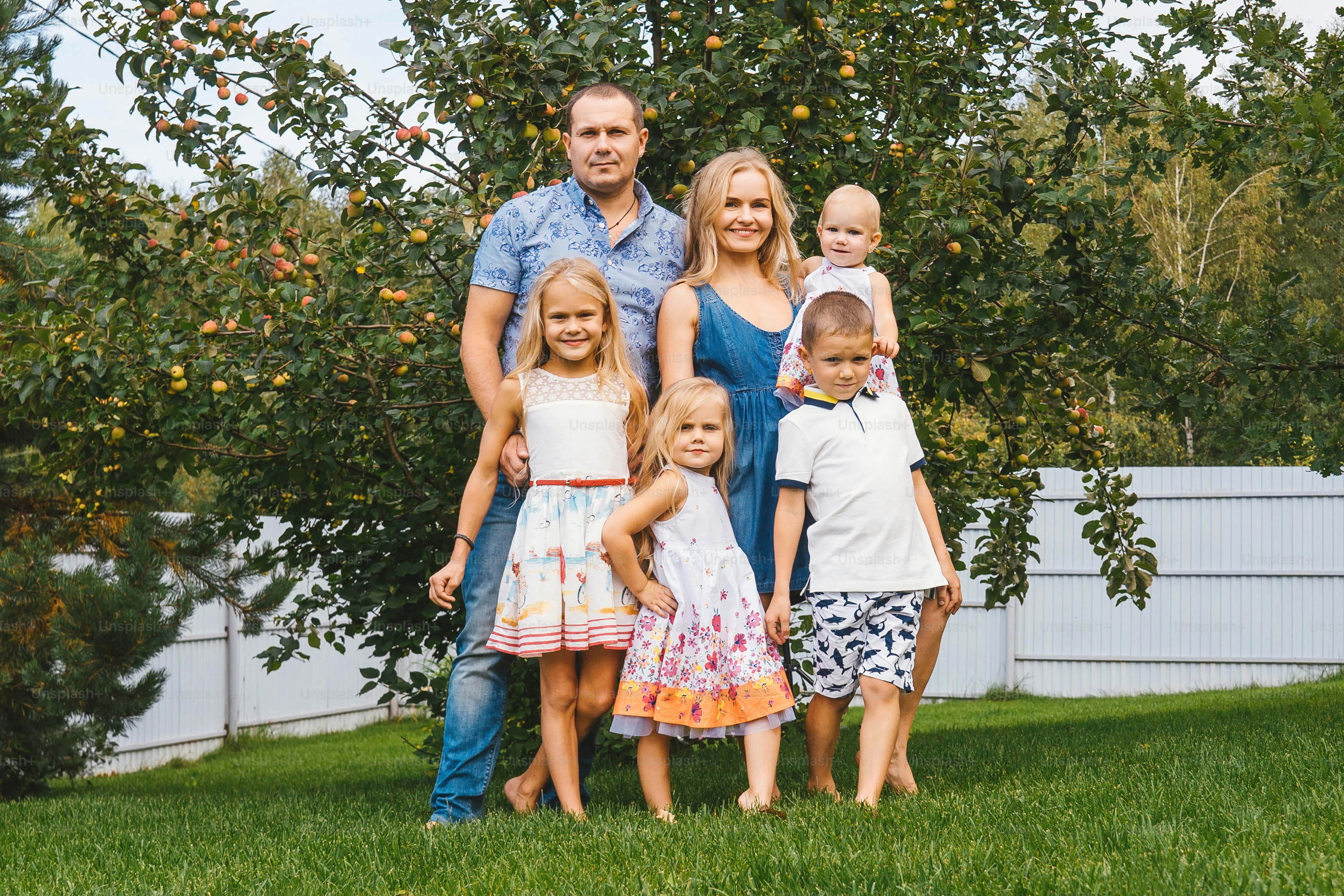 Happy large family with children in garden, apple tree on background ...