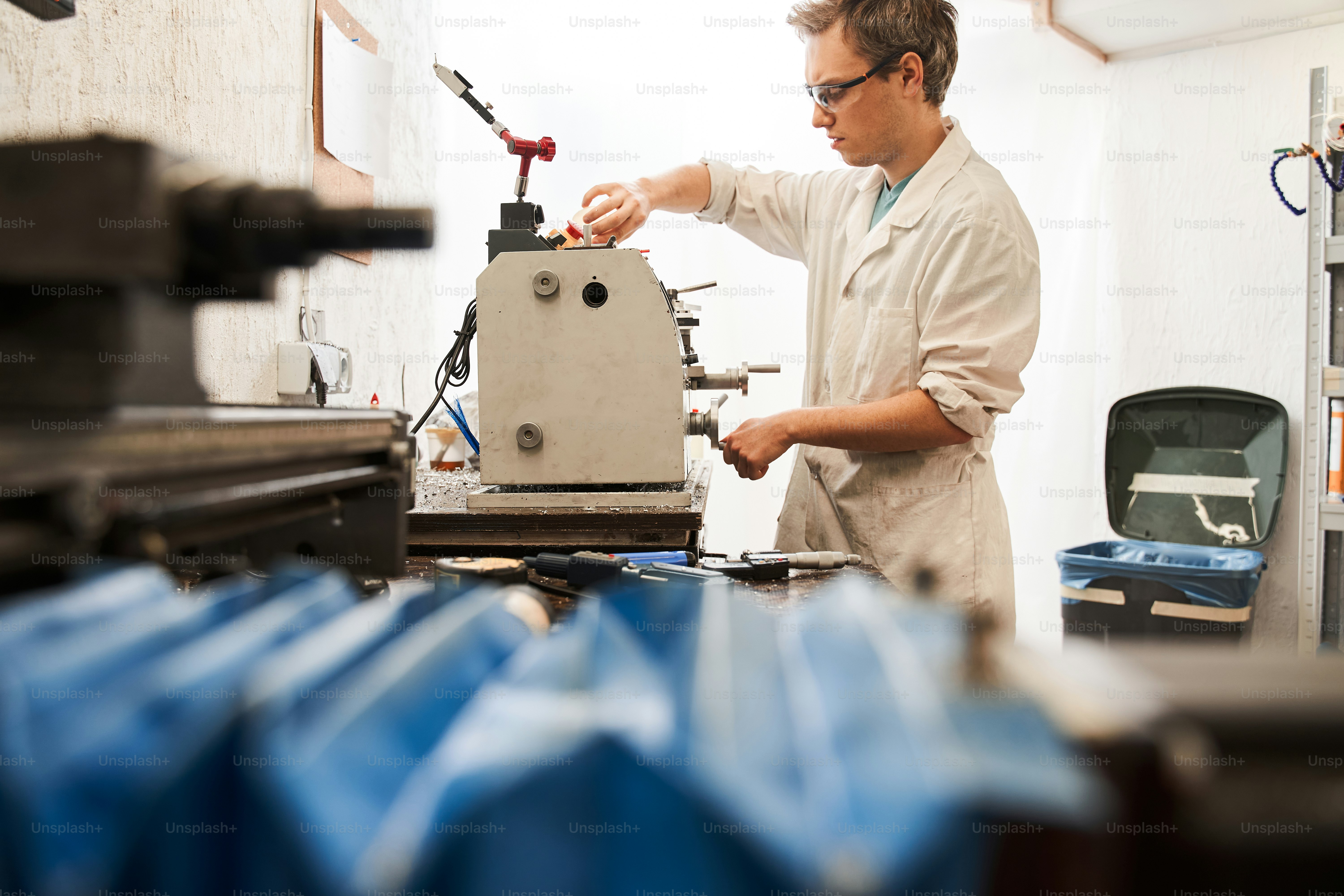 Close up view of the man engineer standing at the special machine and ...