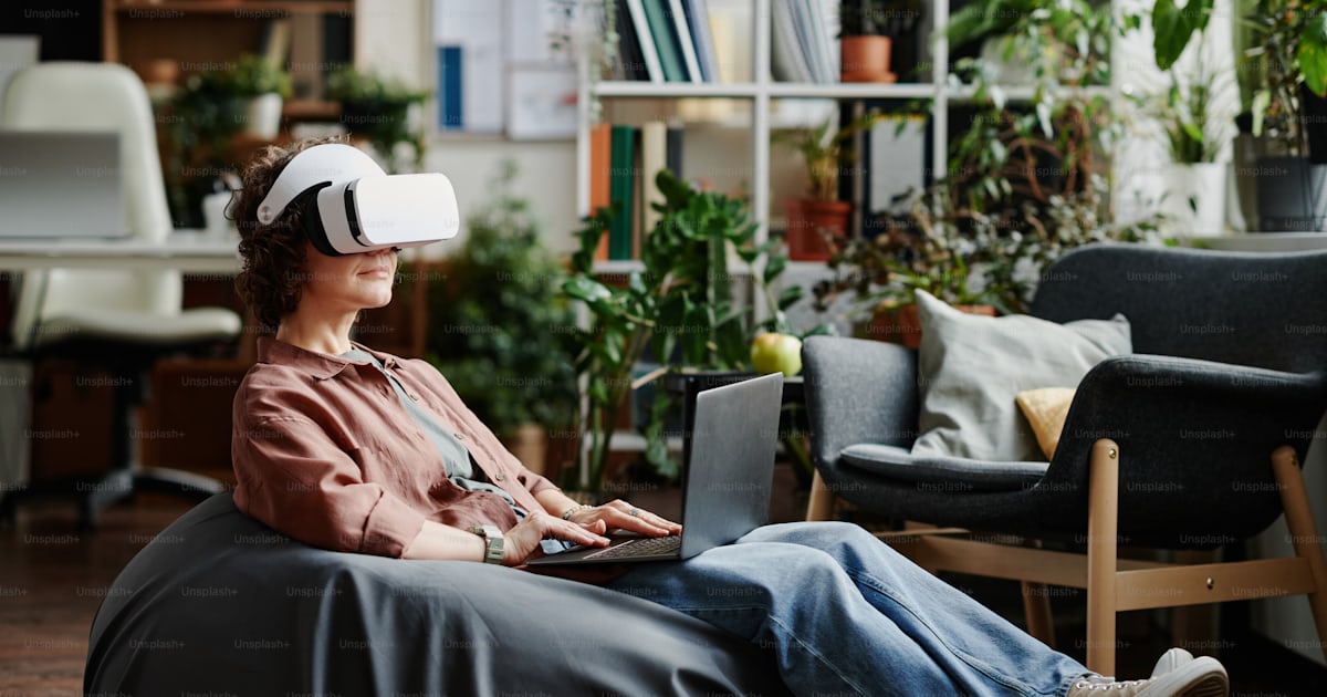 Vr 헤드셋과 노트북을 입은 젊은 현대 사업가가 가방 의자에 앉아 새로운 프로젝트의 발표를 준비하고 있다 사진
