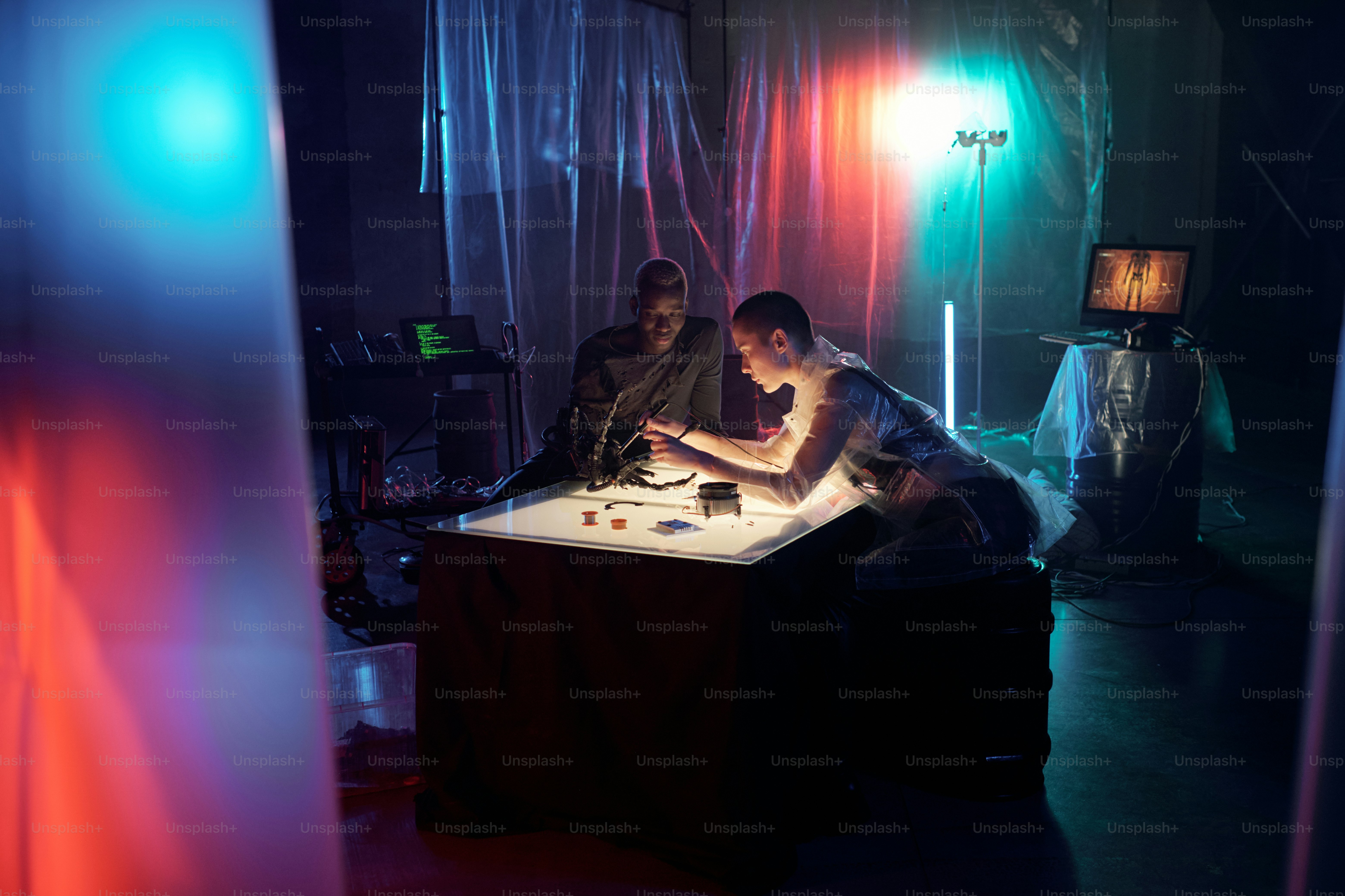 Woman projecting robotic arm on the body of the man who sitting at the ...