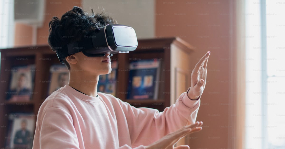 캐주얼웨어를 입고 Vr 고글을 쓴 모바일 대학생이 3차원 현실에서 움직이면서 가상 화면을 만지고 있다 사진 Unsplash의