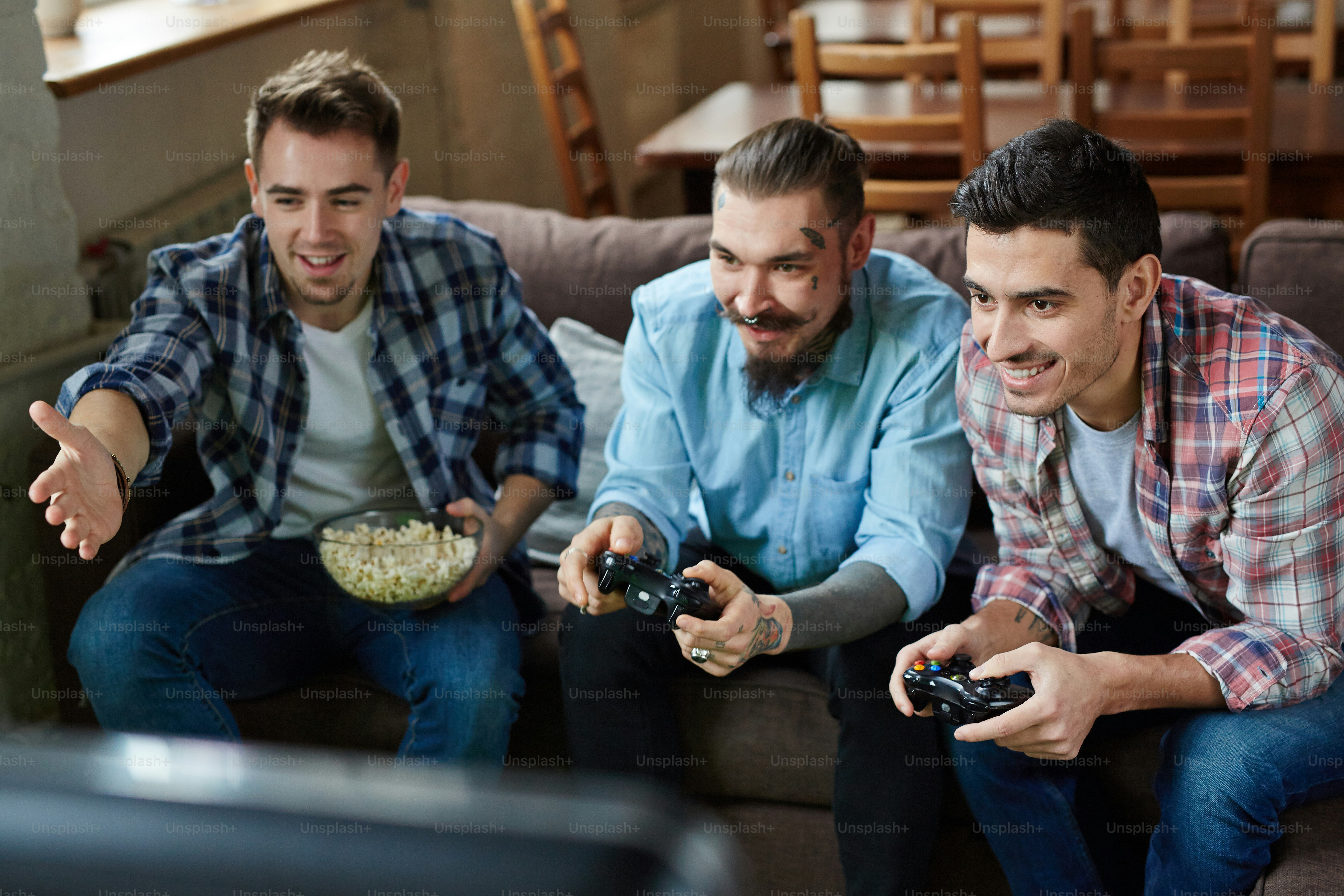 Three happy guys playing video game in team photo – Happiness Image on ...