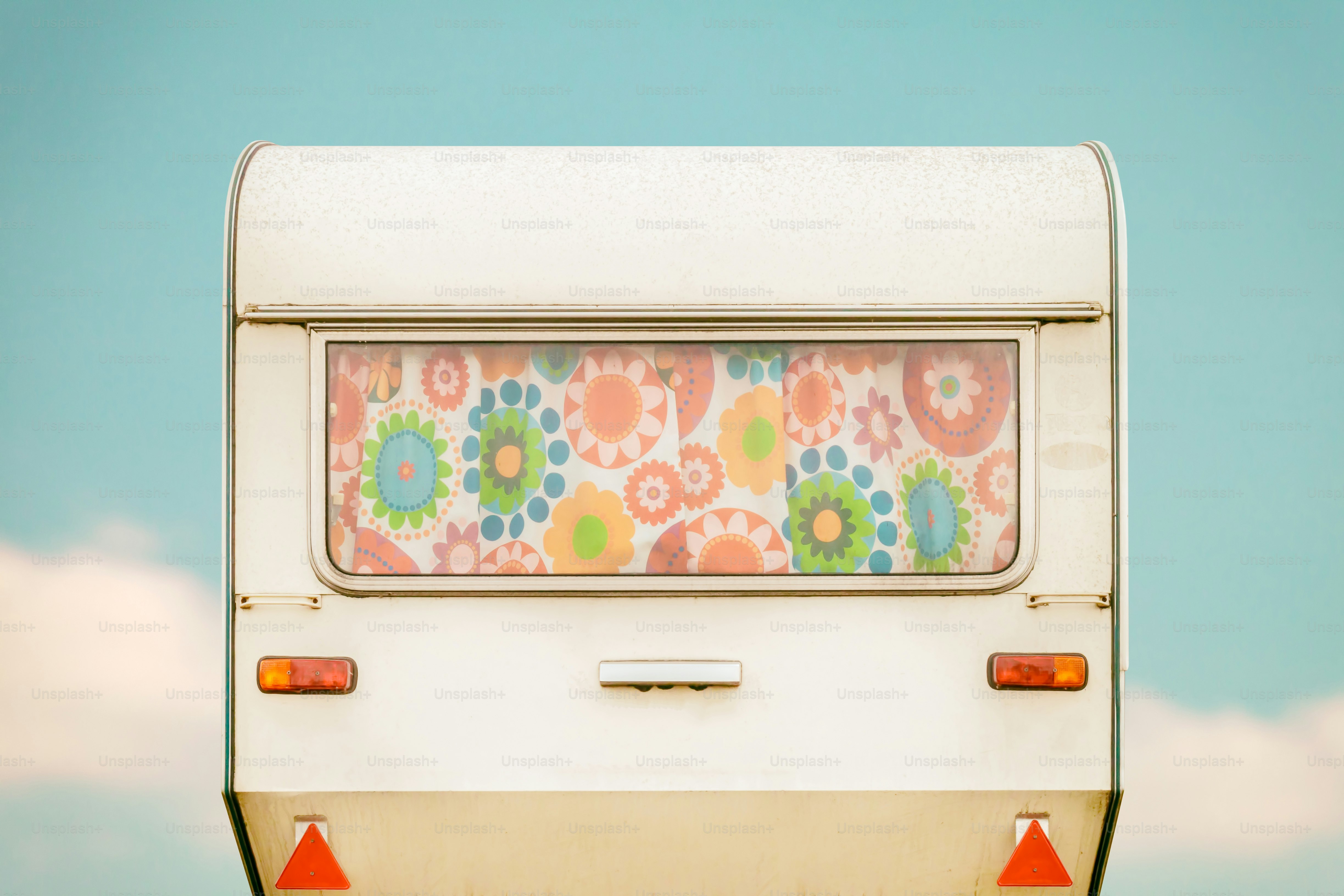 Vintage rear of a caravan with colourful seventies flower curtains ...
