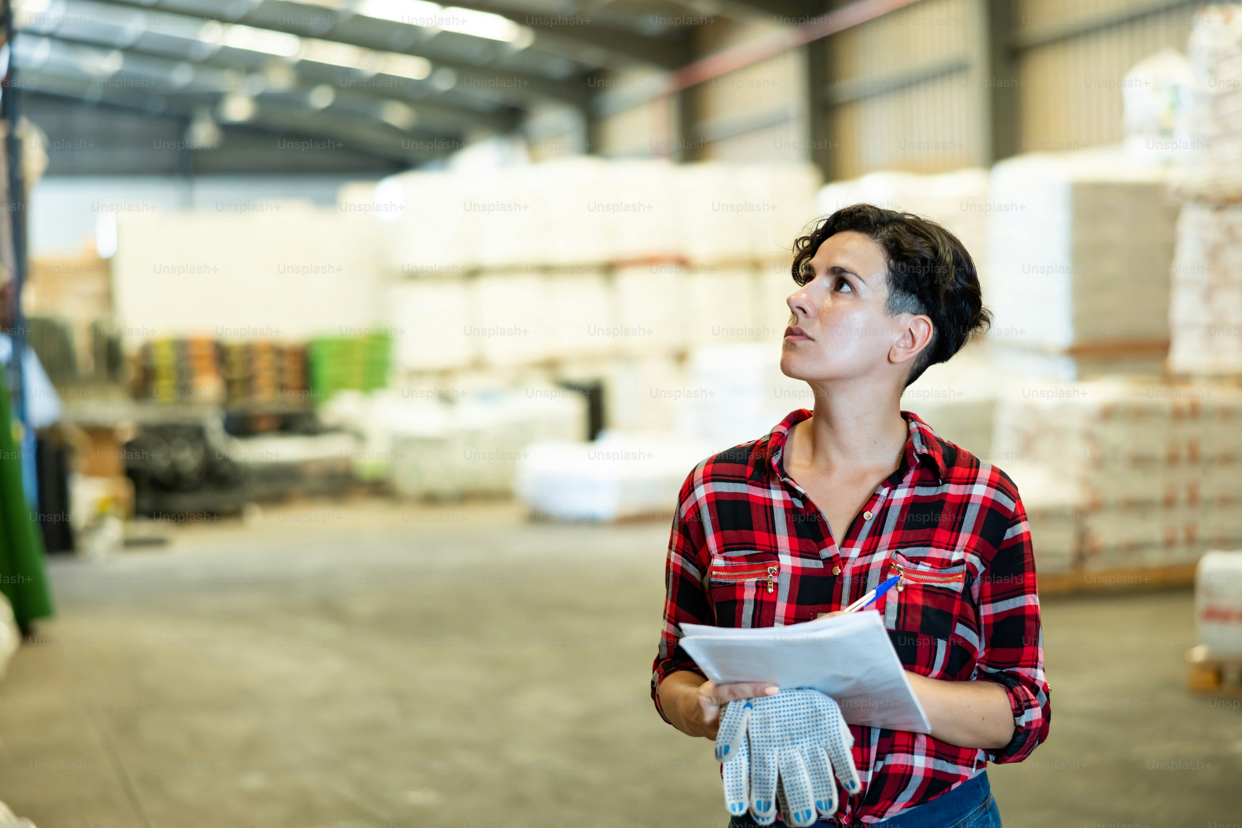 Latin woman making stock control, verifying documents while working ...