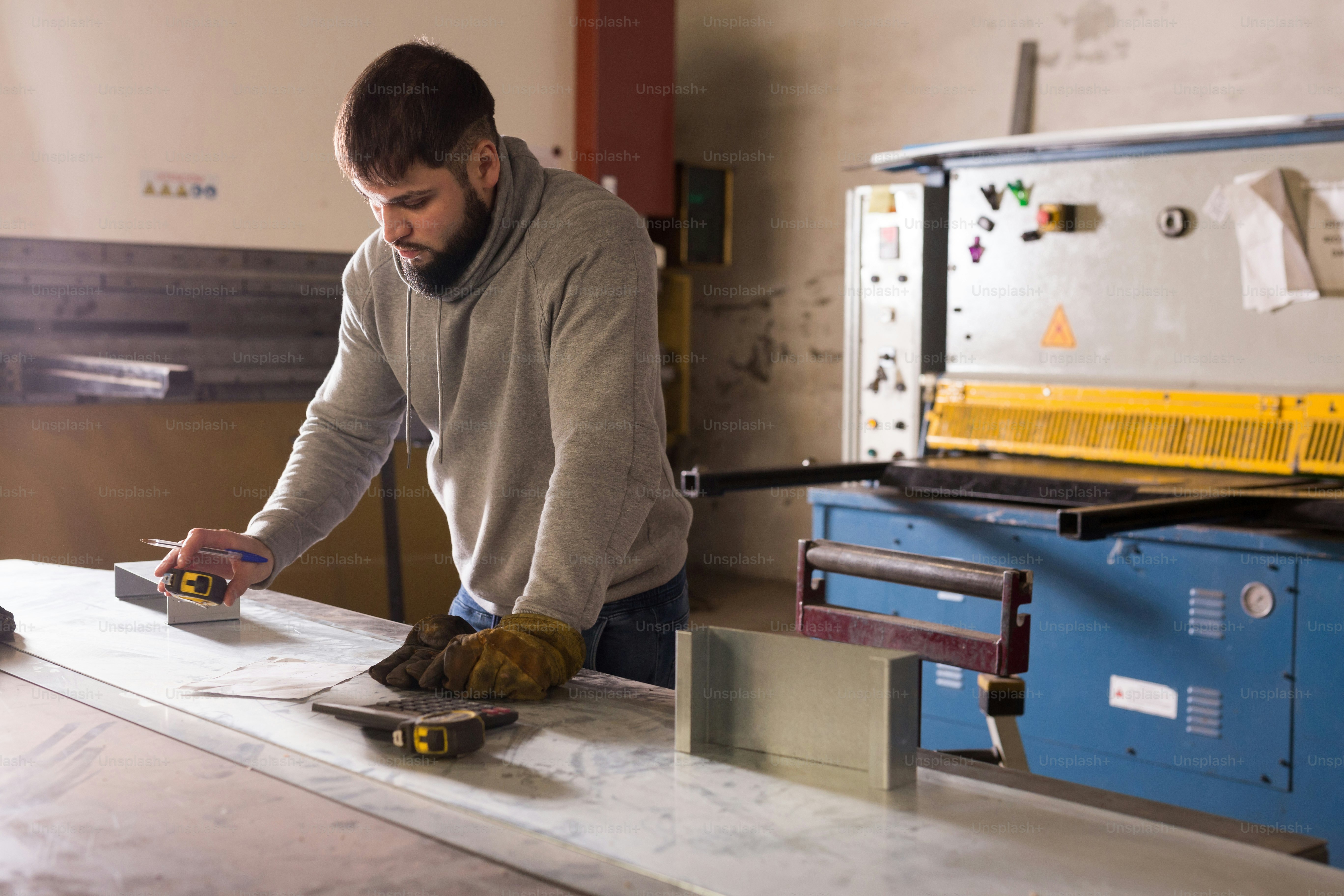 Foto zum Thema Der Vorarbeiter misst das Teil und macht sich Notizen ...