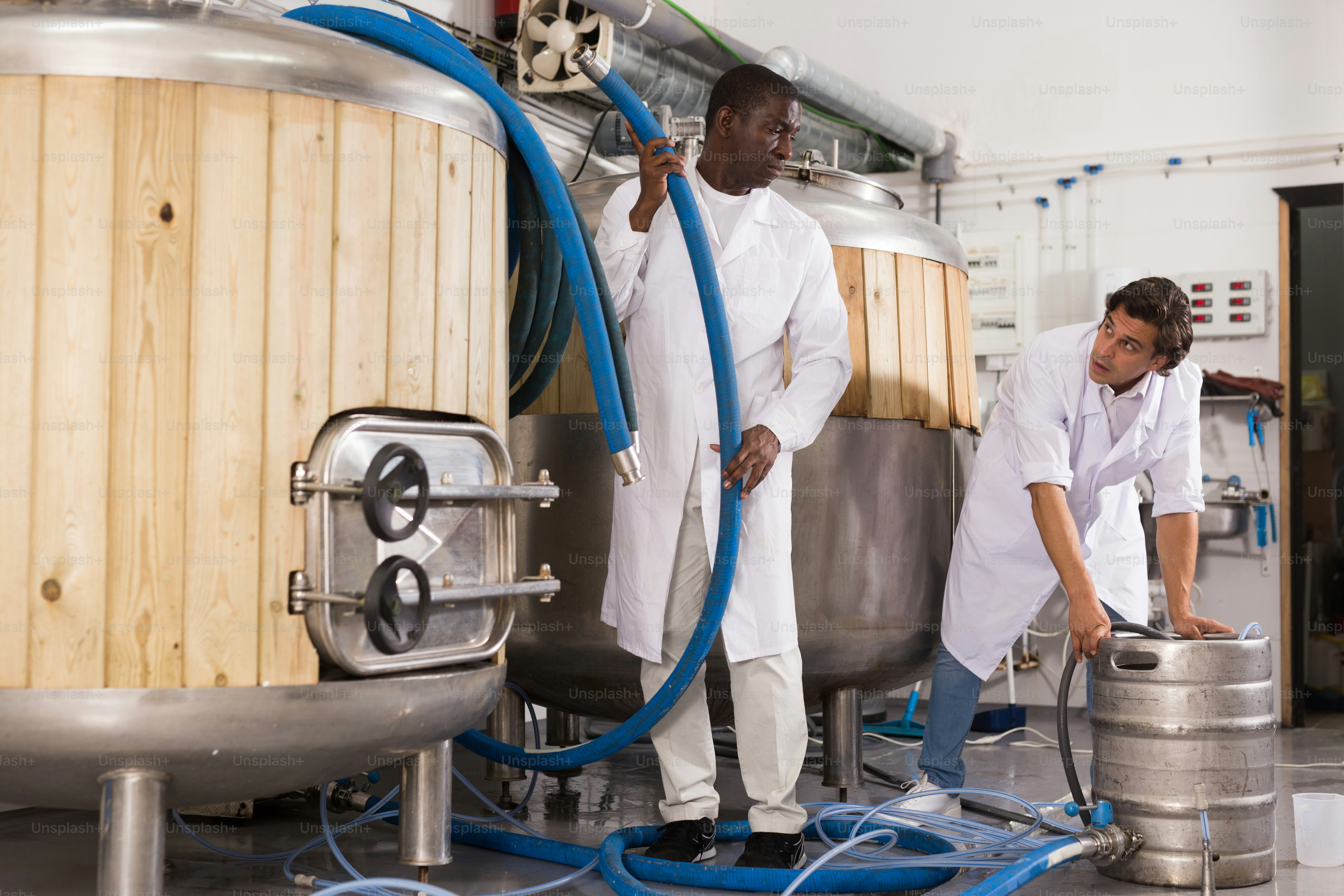 Portrait of brewers working on his workplace in the brew-house photo ...