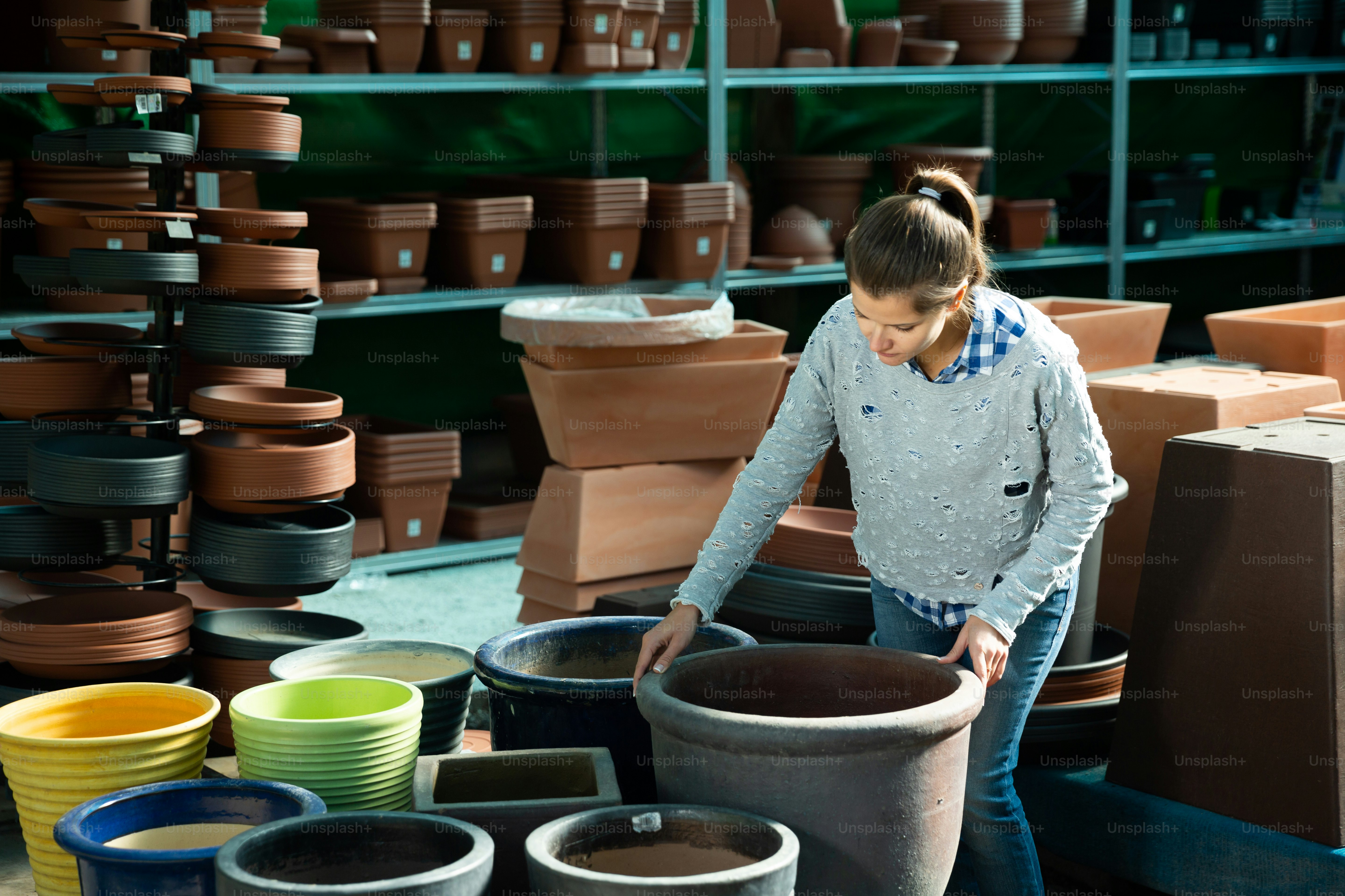 Woman chooses pots clay pots in store warehouse photo – Land Image on ...