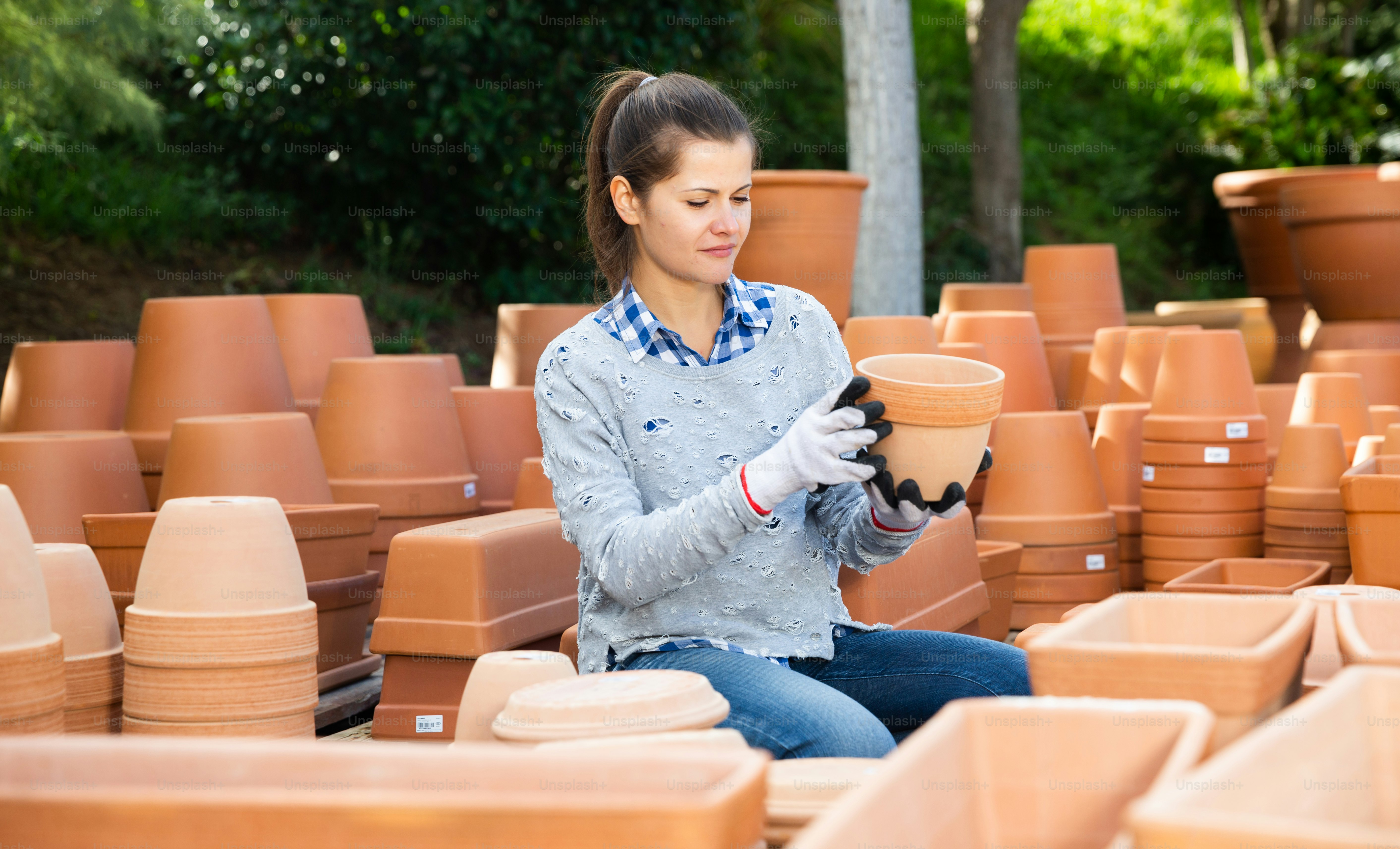 Woman chooses pots clay pots in store warehouse photo – Gardening Image ...