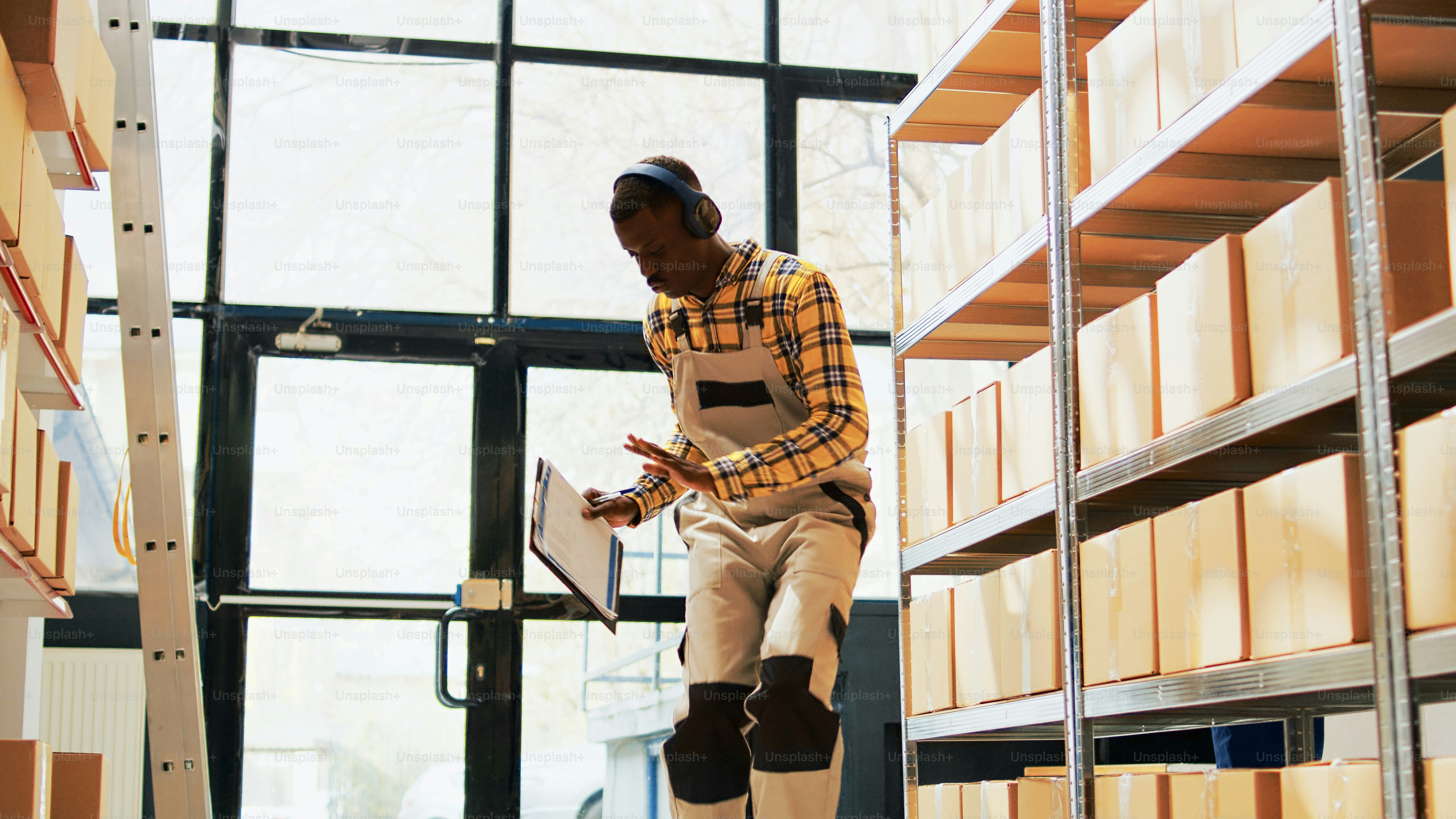 Male worker showing dance moves in warehouse space, working in depot ...