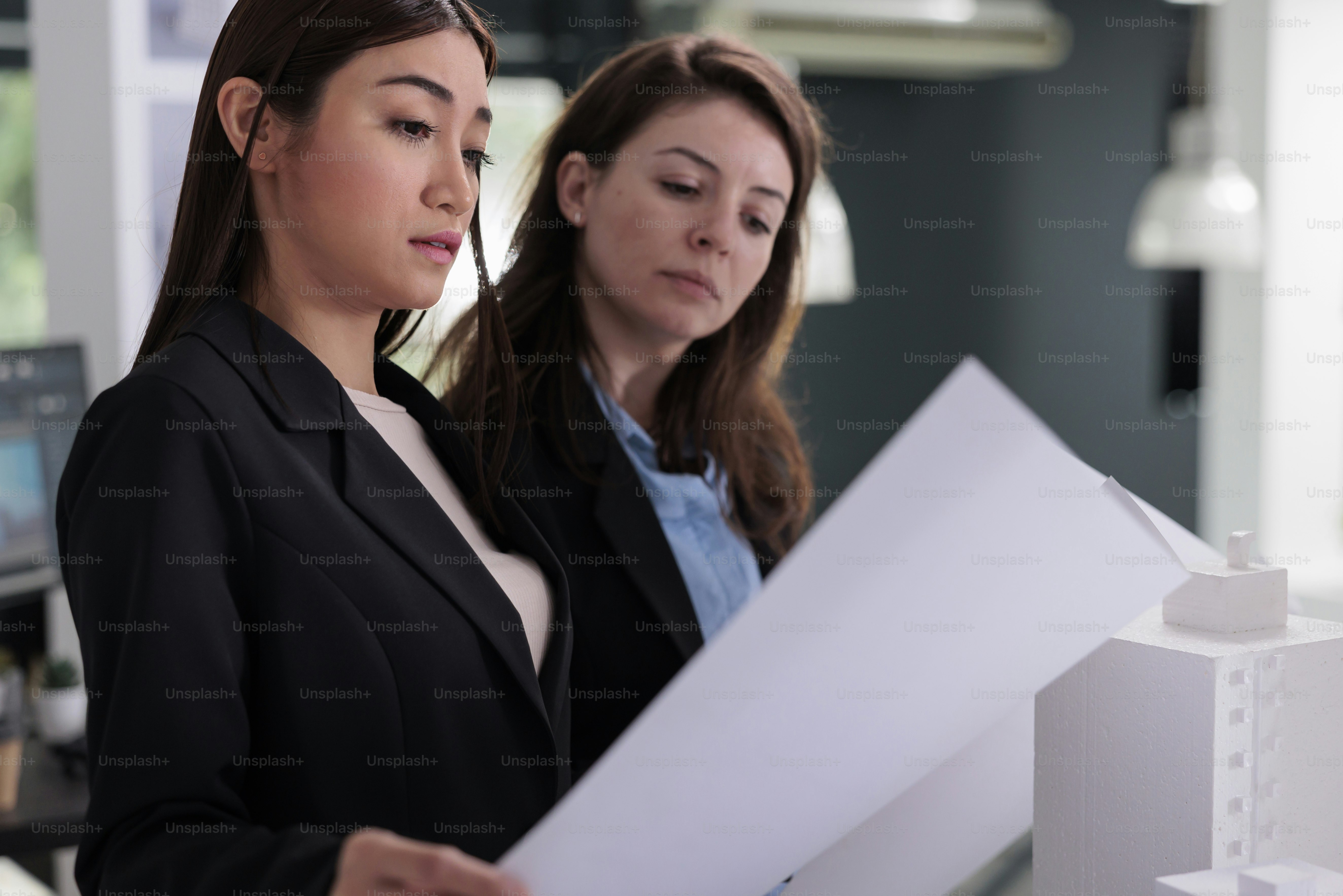 Foto zum Thema Architekten, die sich die Blaupause ansehen und am ...