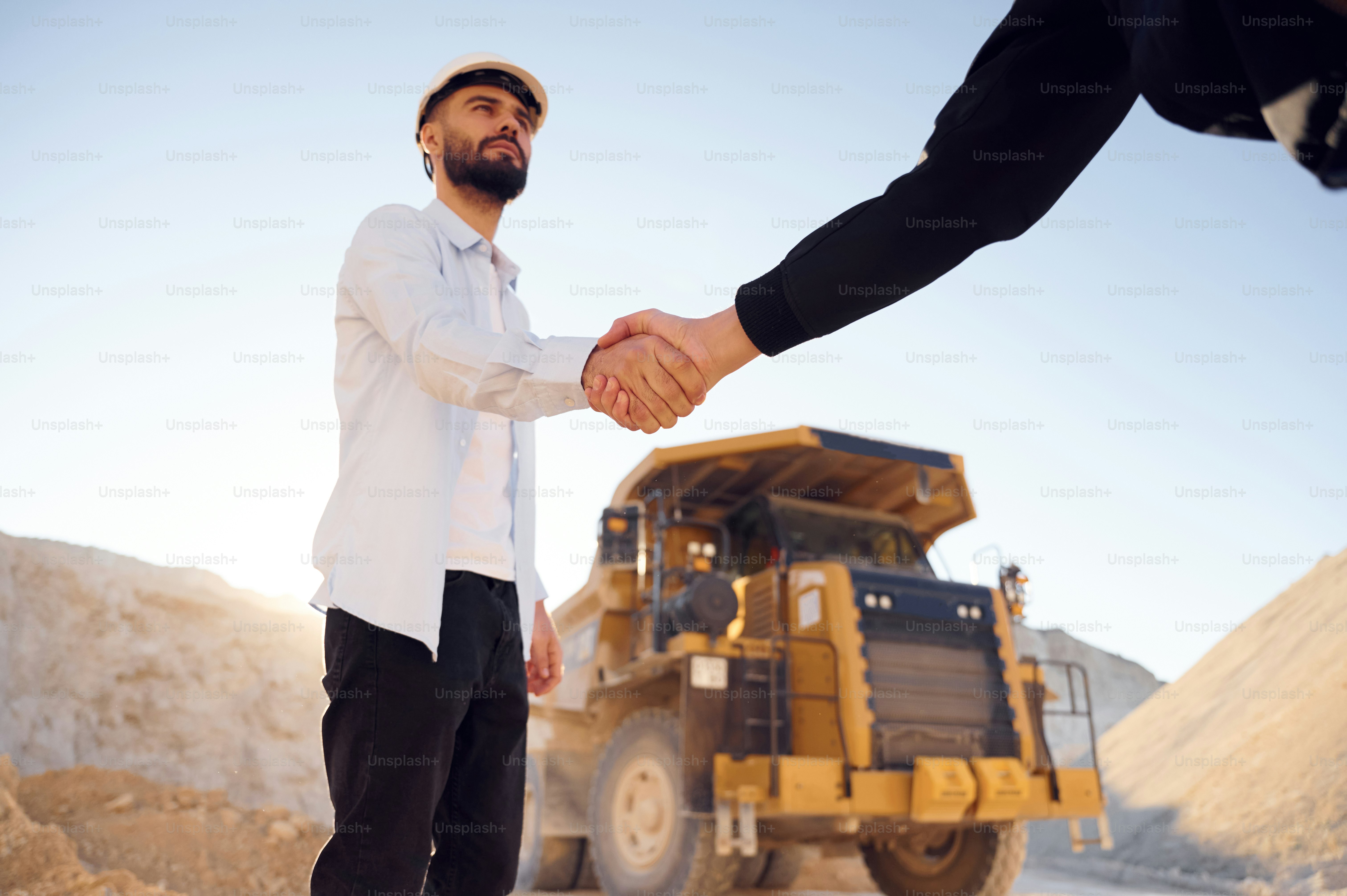 Quarry worker making a deal with colleague. Shaking hands. photo ...