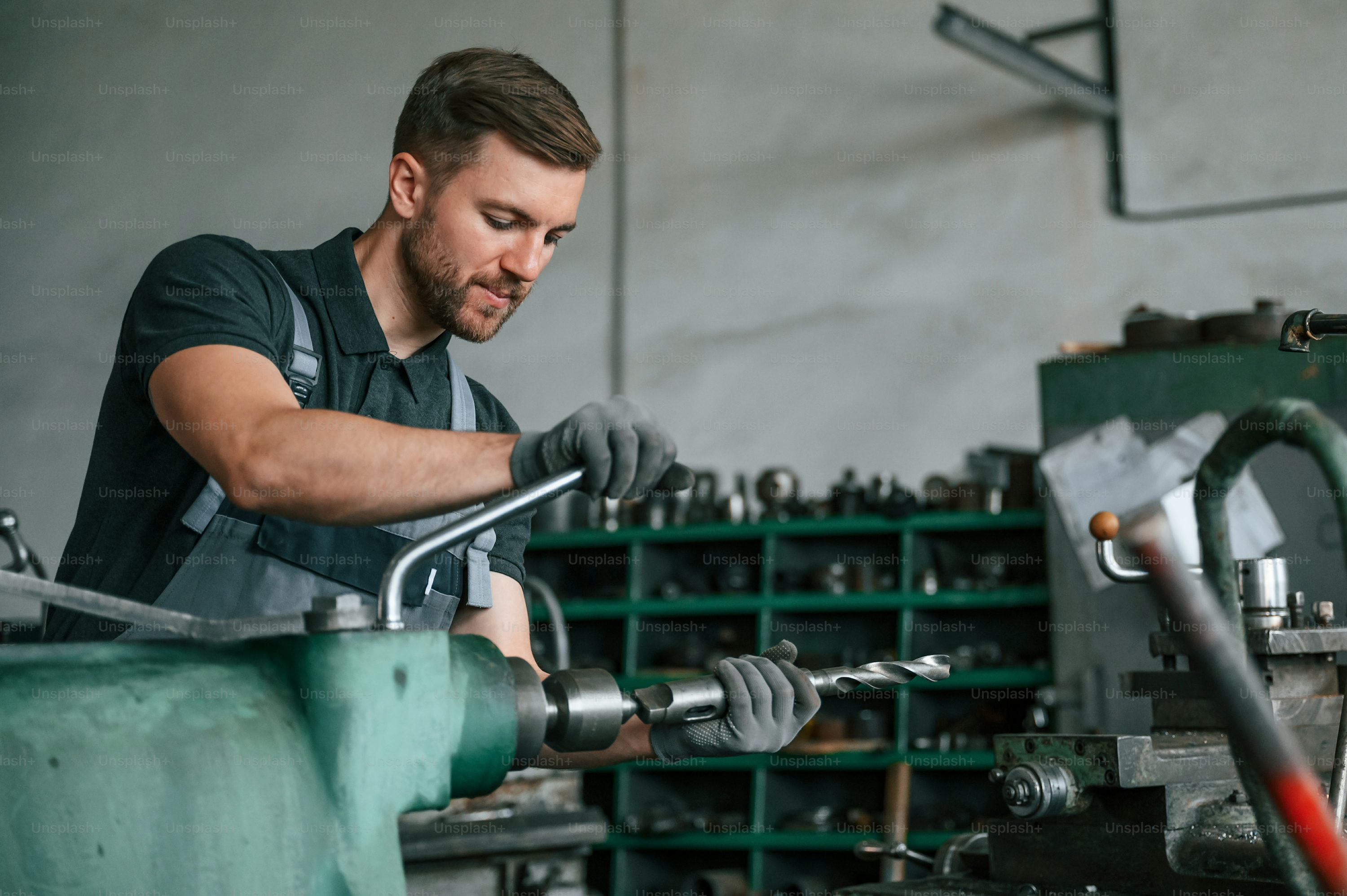Metal processing device. Man in uniform is in workstation developing ... Metal processing device. Man in uniform is in workstation developing ...
