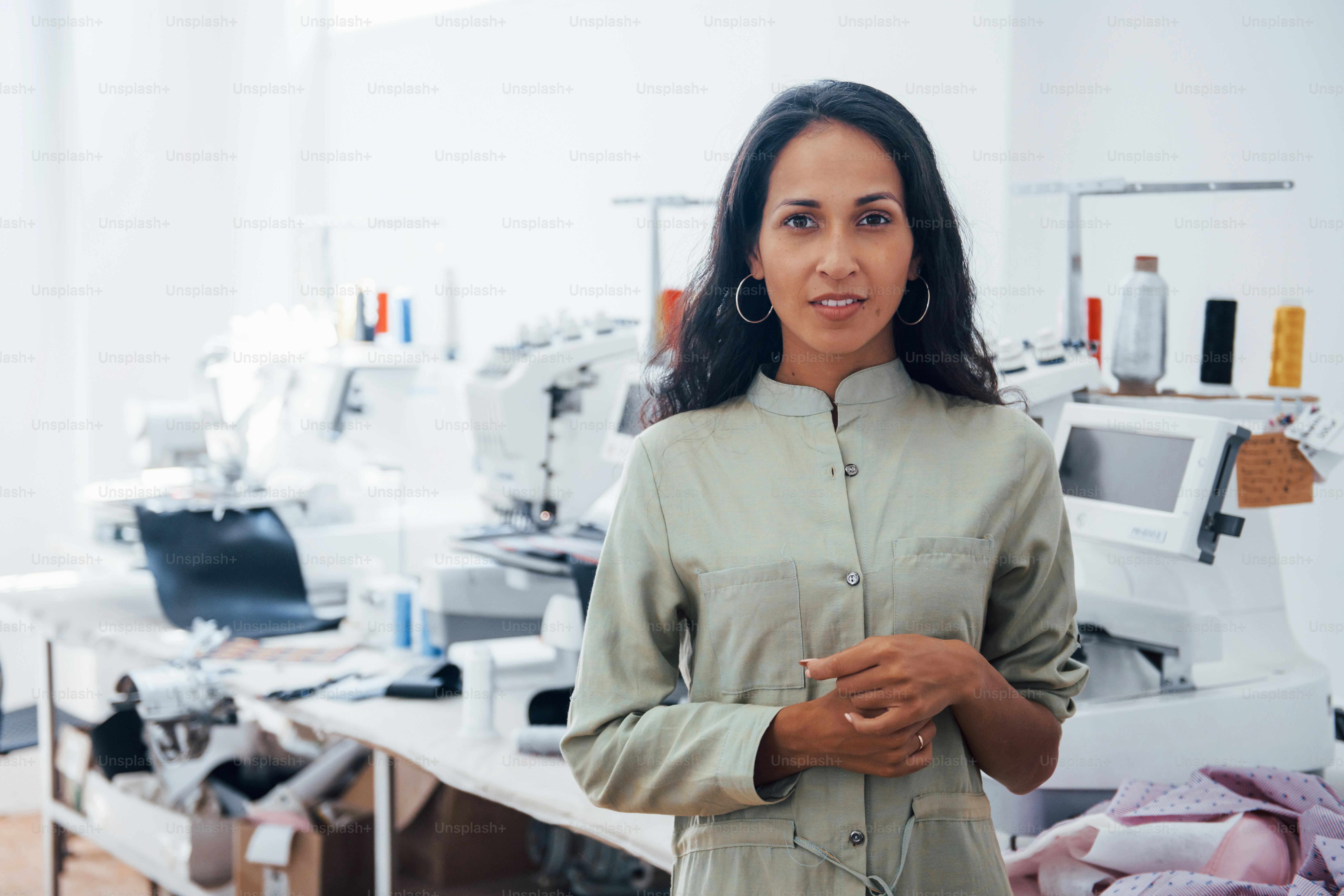 Beautiful female worker is in the sewing factory at daytime. photo ...