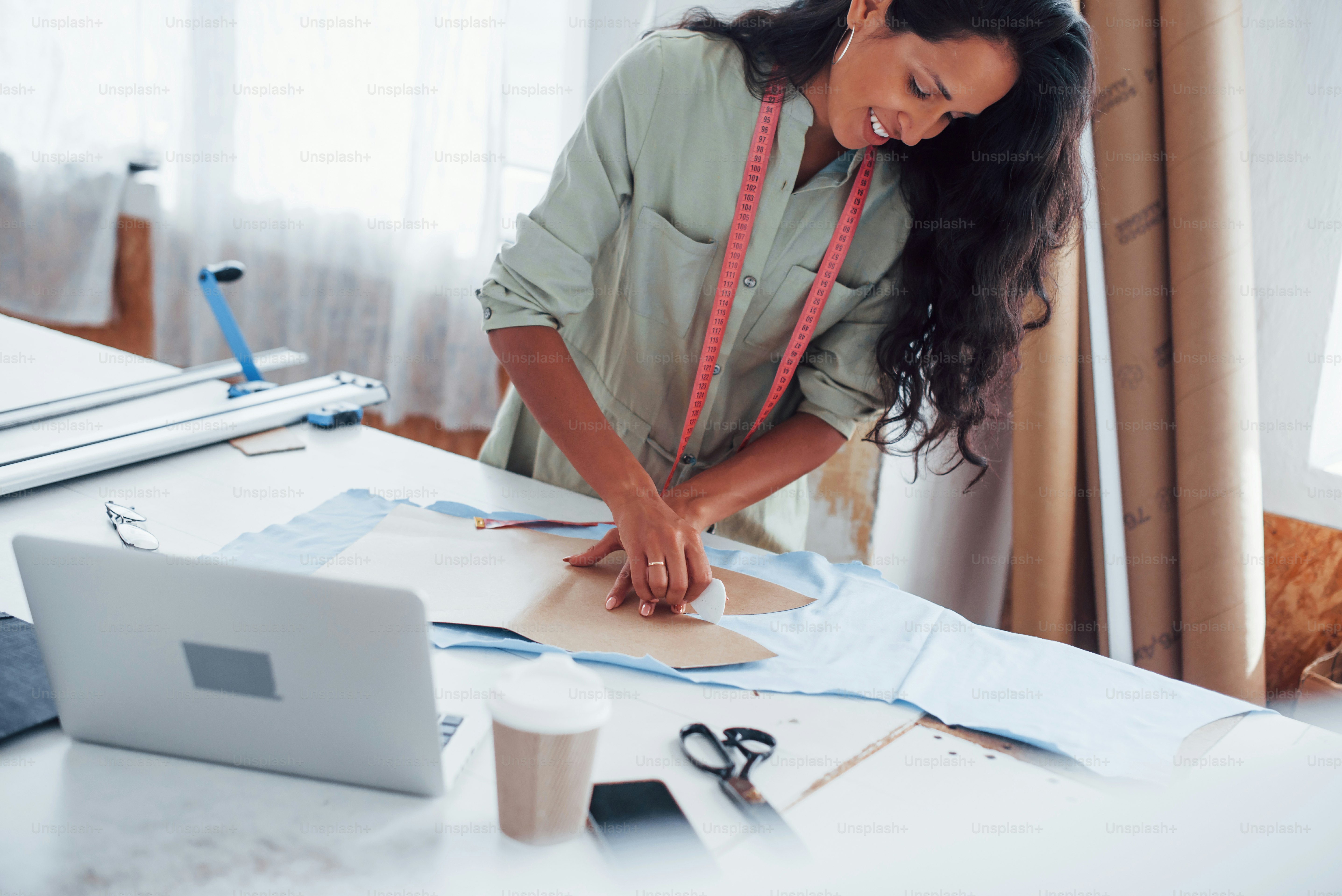 Busy with cloth. Beautiful female worker is in the sewing factory ...