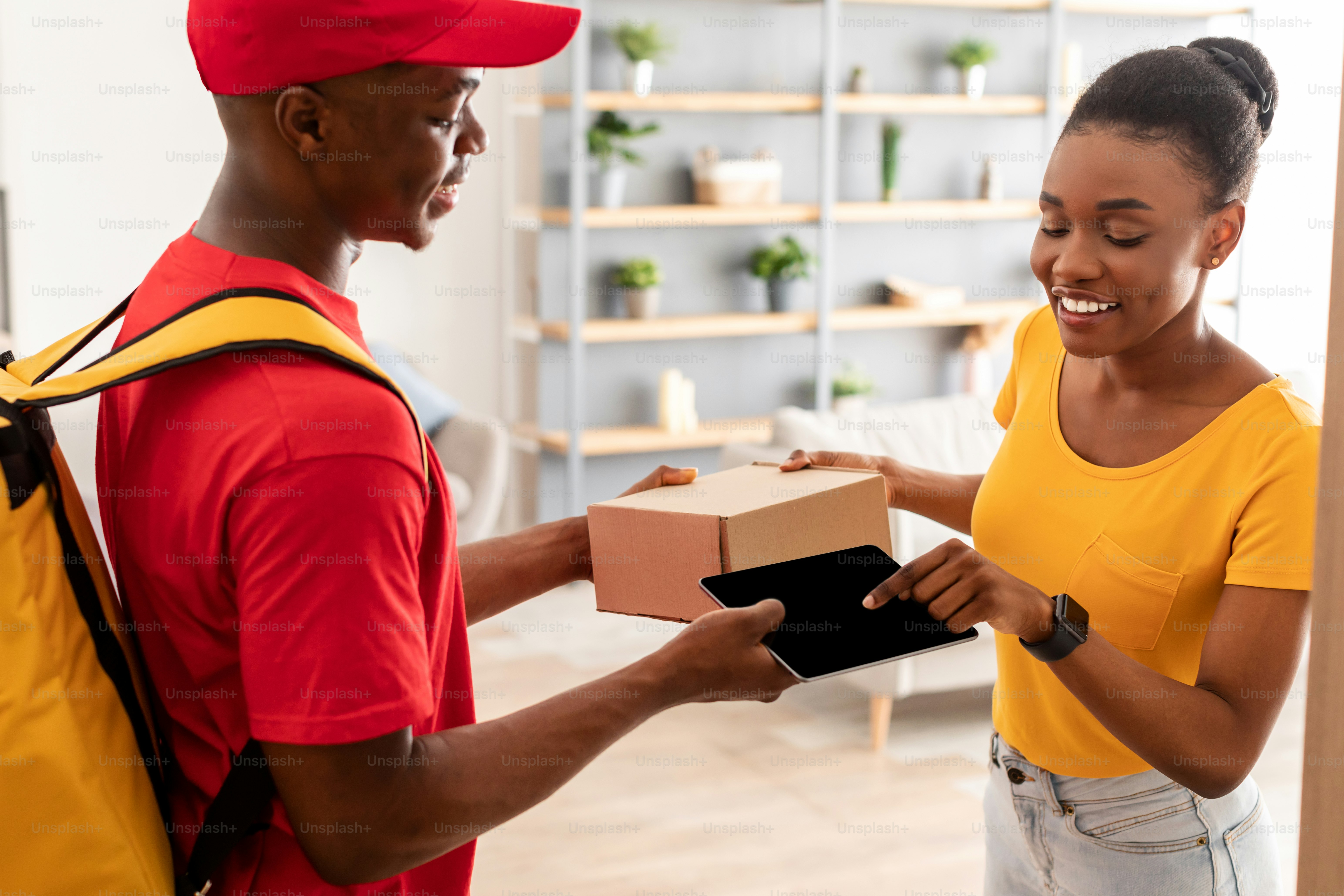 Black Lady Receiving Parcel From Courier And Scanning Fingerprint For ...
