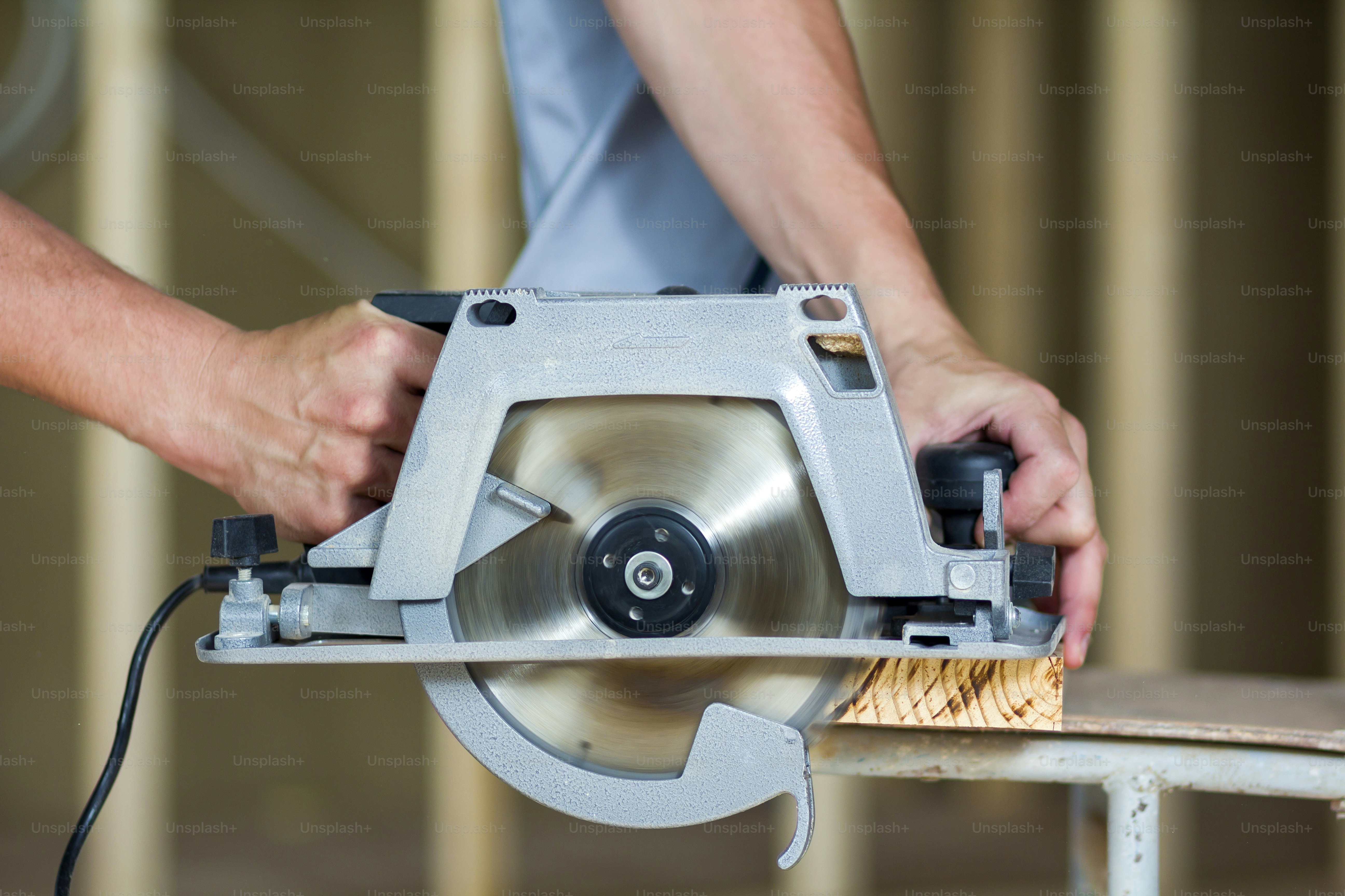 Close-up of muscular carpenter hands using new shiny modern powerful ...