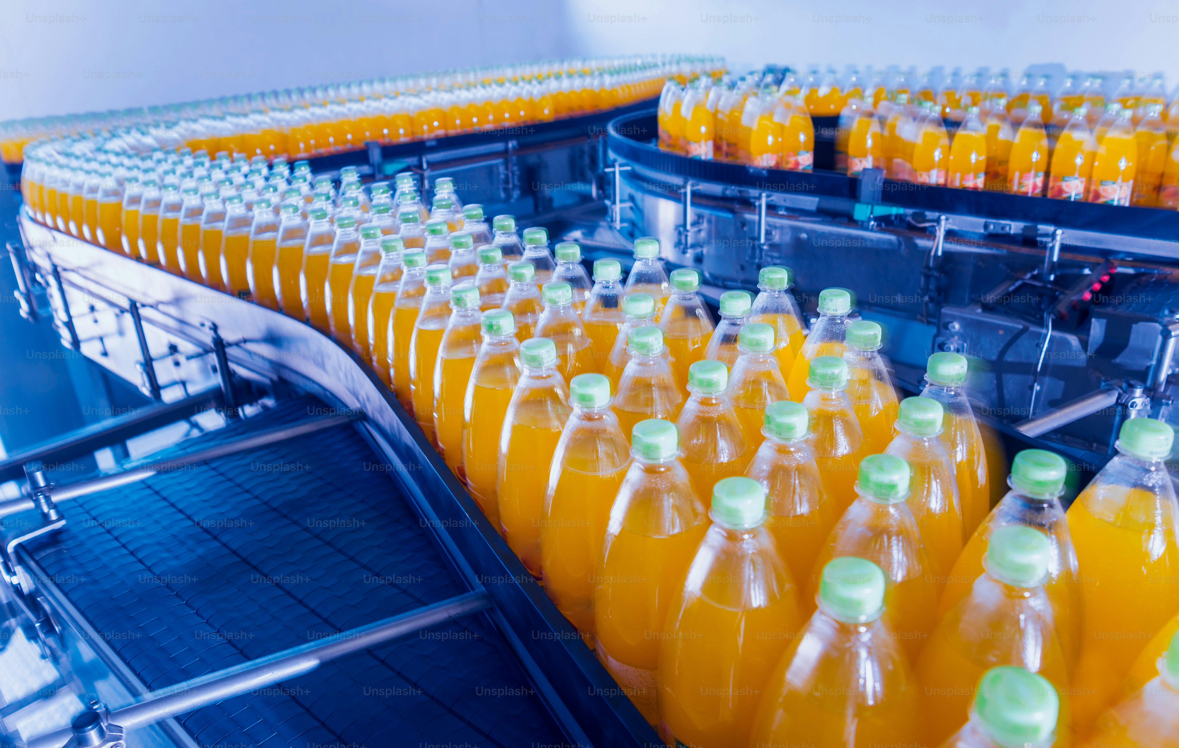 Beverage factory interior. Conveyor with bottles for juice or water ...