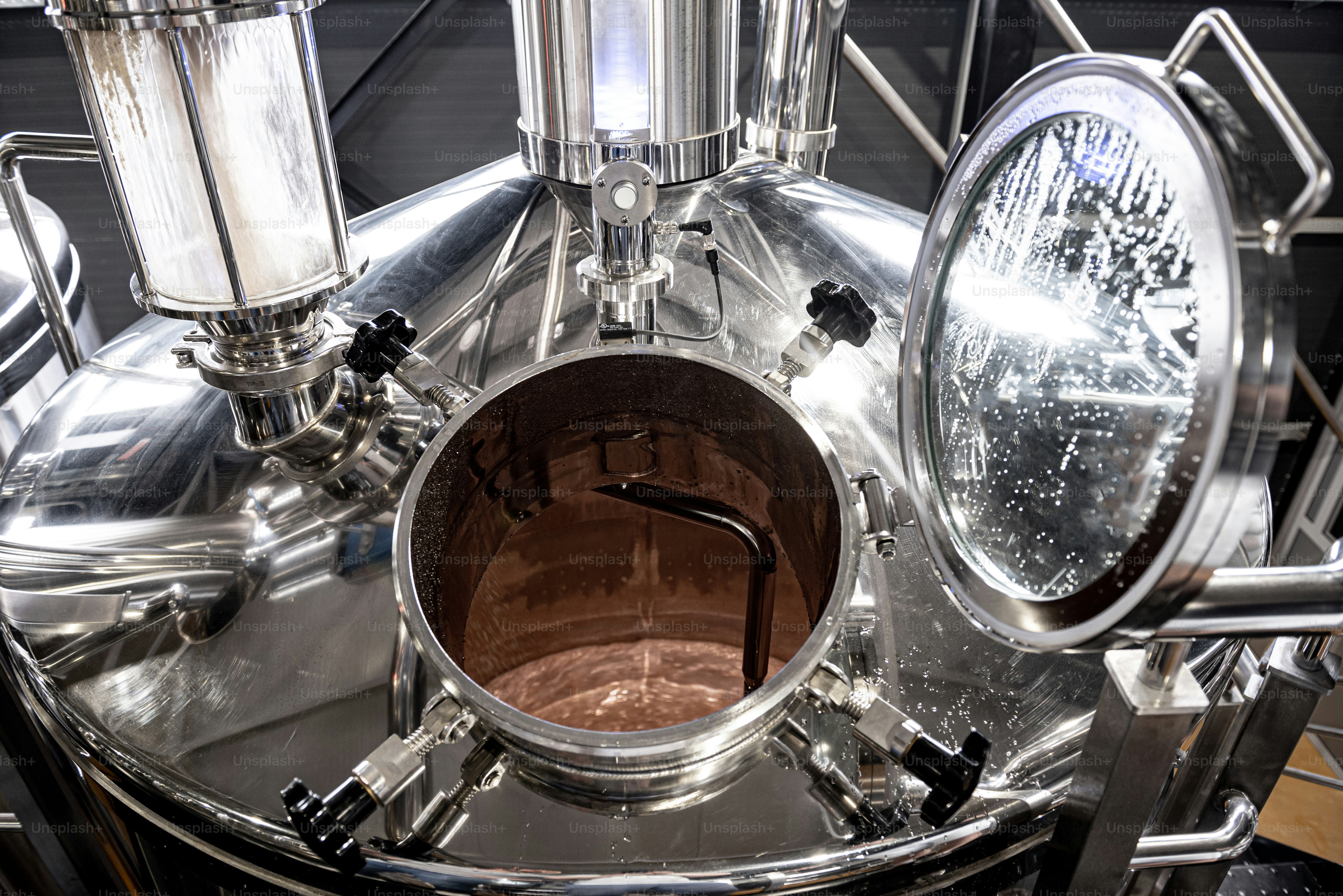 The valves and pipes at a craft modern brewery wall. photo – Steel ...