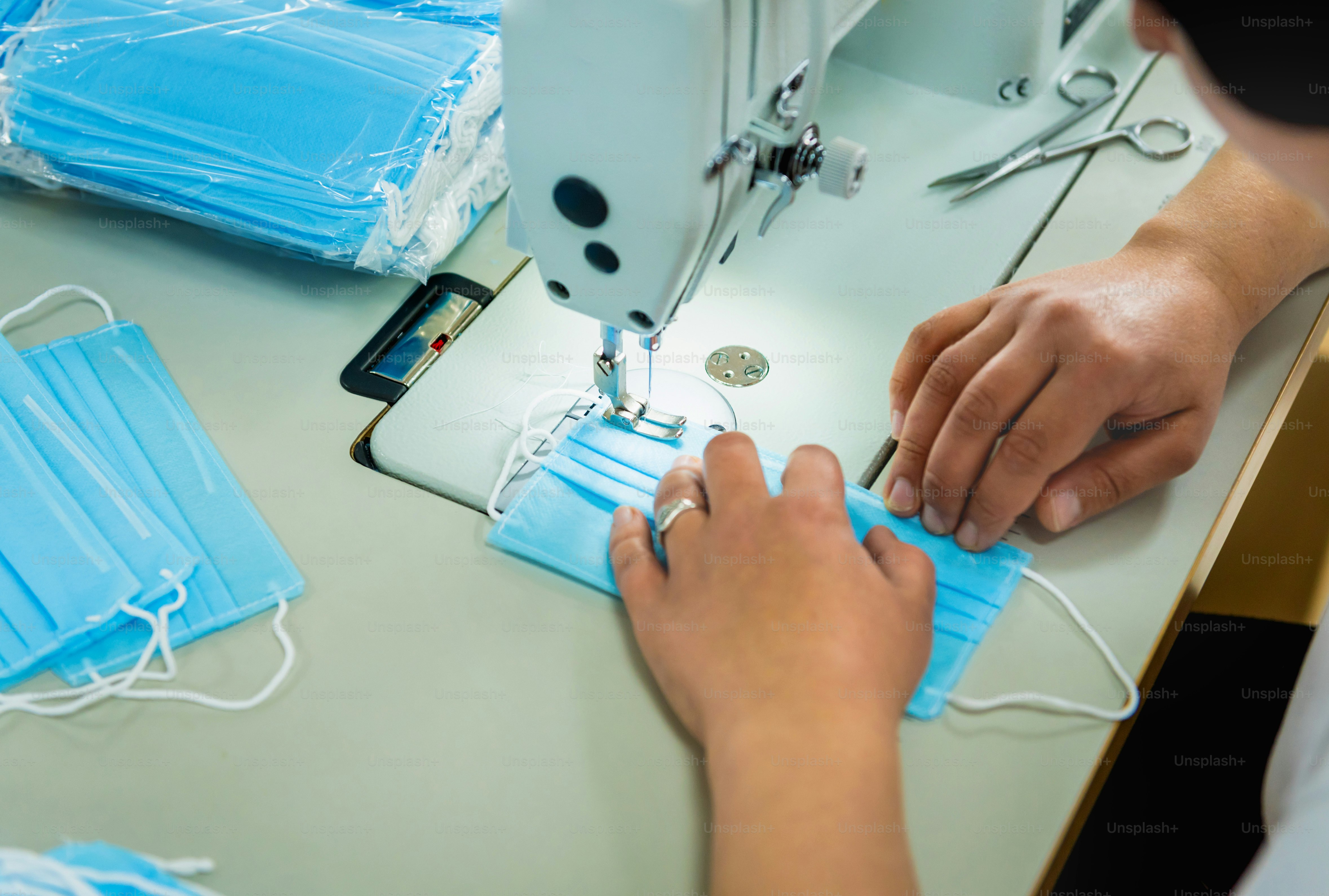 Woman sew the facial medical at sewing machine. Coronavirus pandemia ...