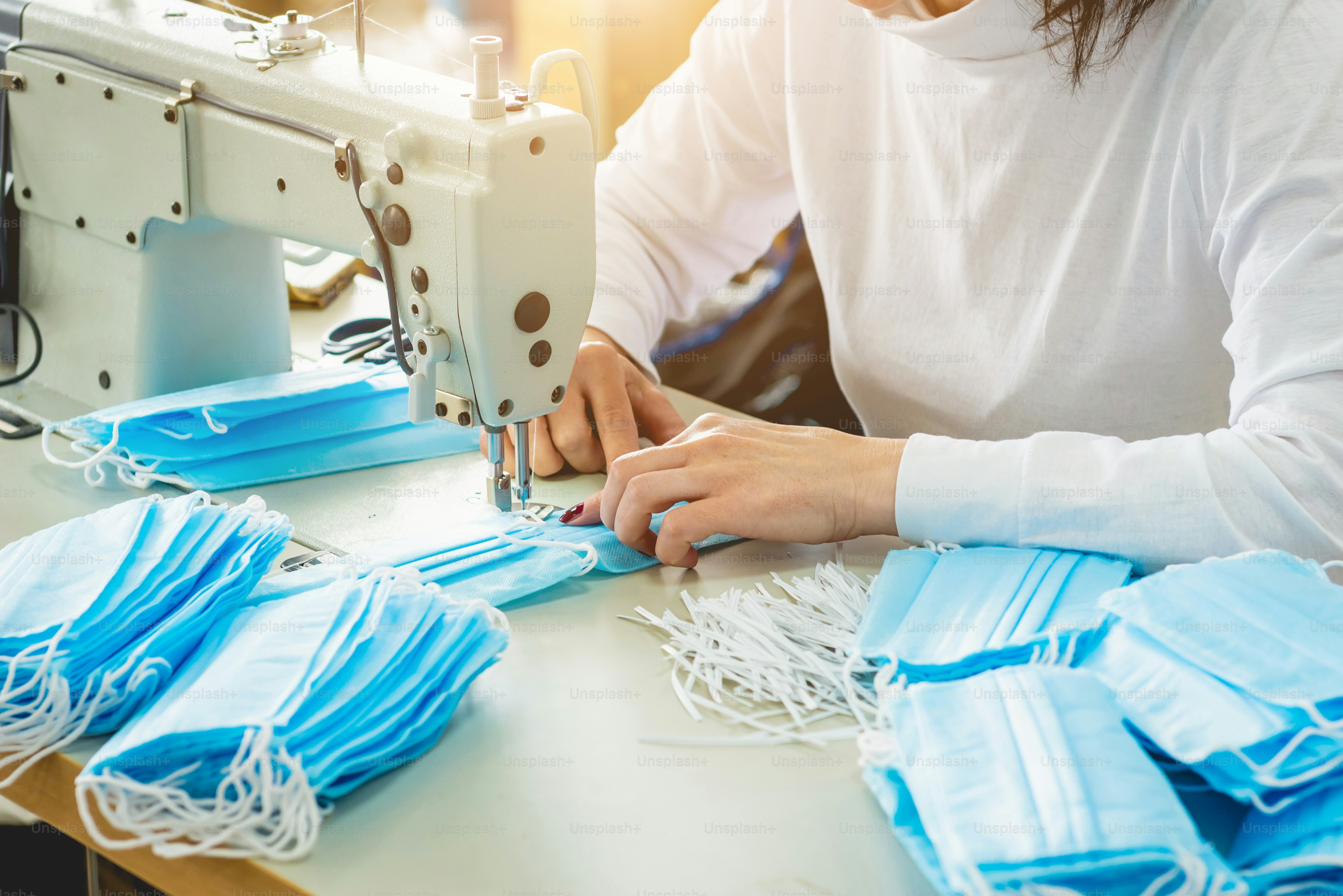 Woman sew the facial medical at sewing machine. Coronavirus pandemia ...